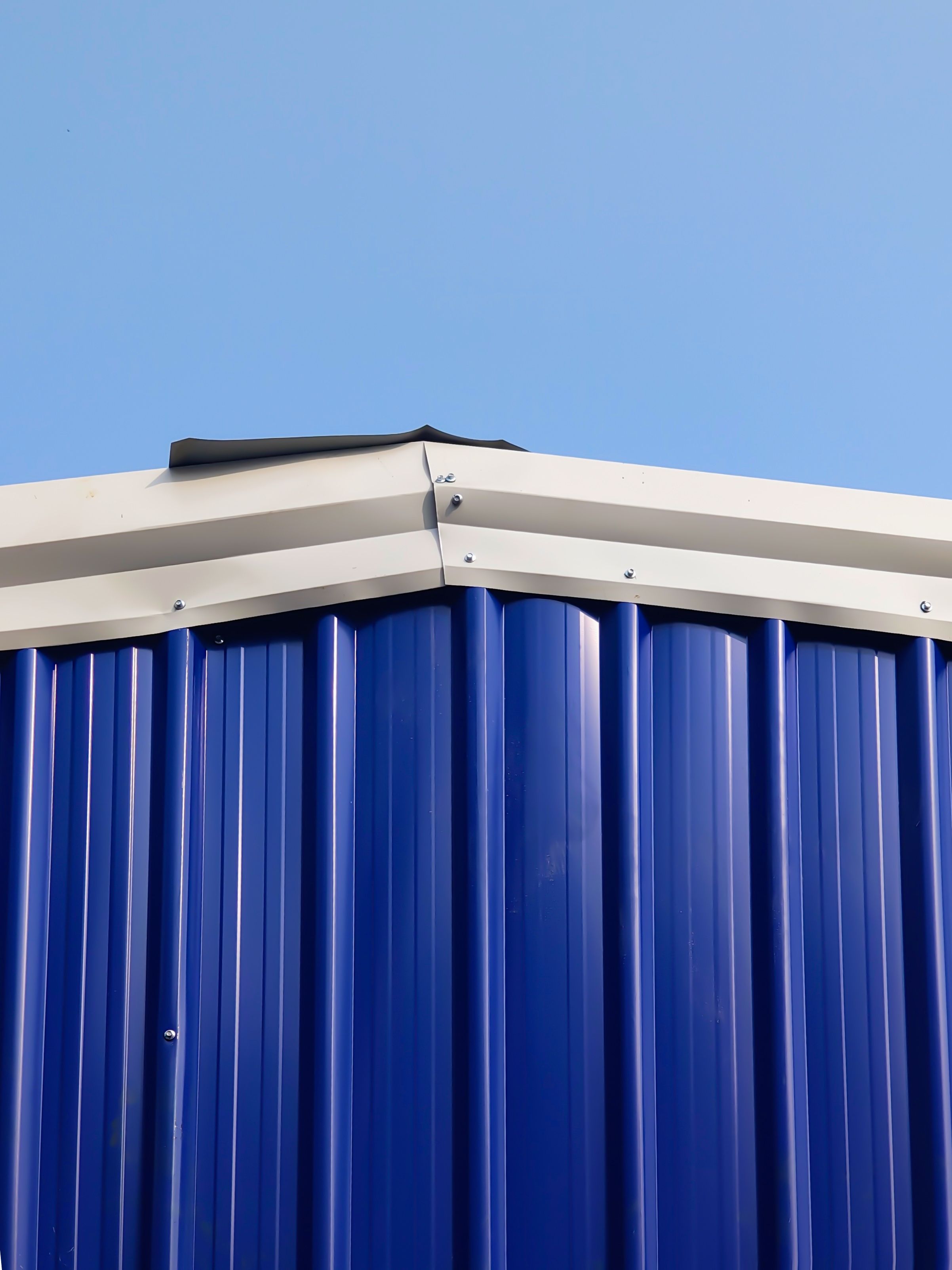 Blue Metal Building with Clear Sky View · Free Stock Photo