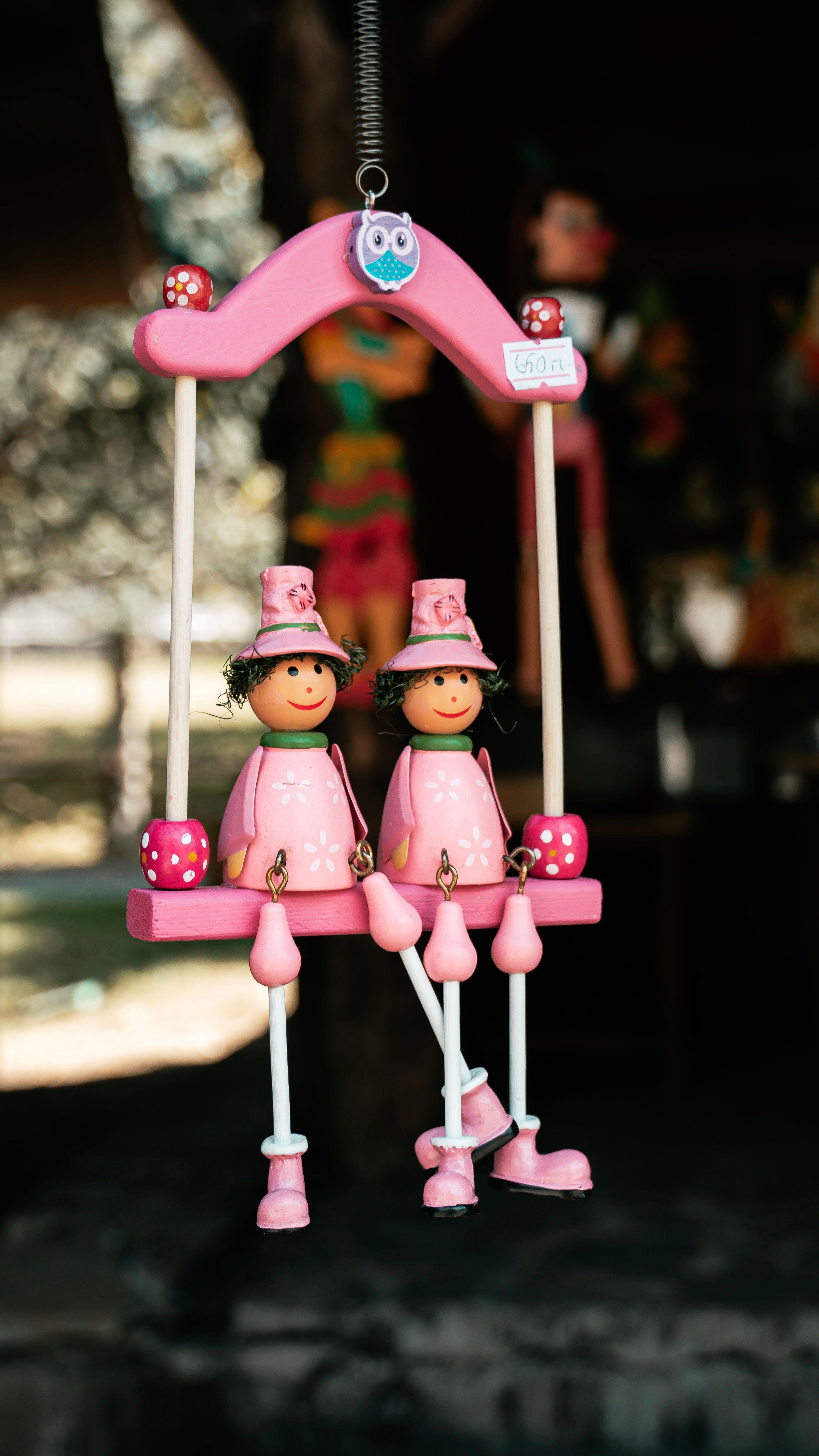 Charming Pink Toy Swing with Dolls Hanging Outdoors · Free Stock Photo