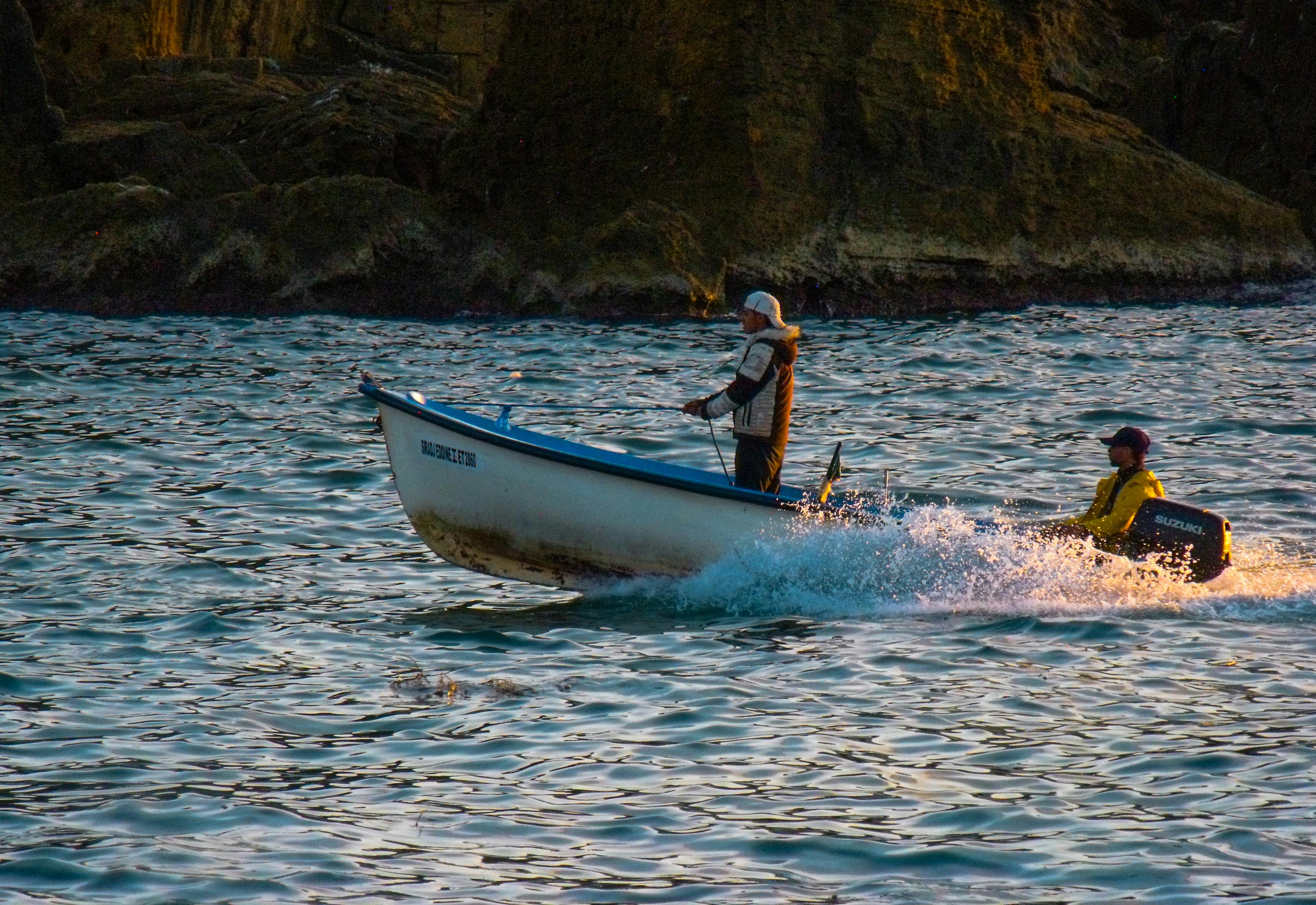 Men Boating on Serene Waters at Sunset · Free Stock Photo