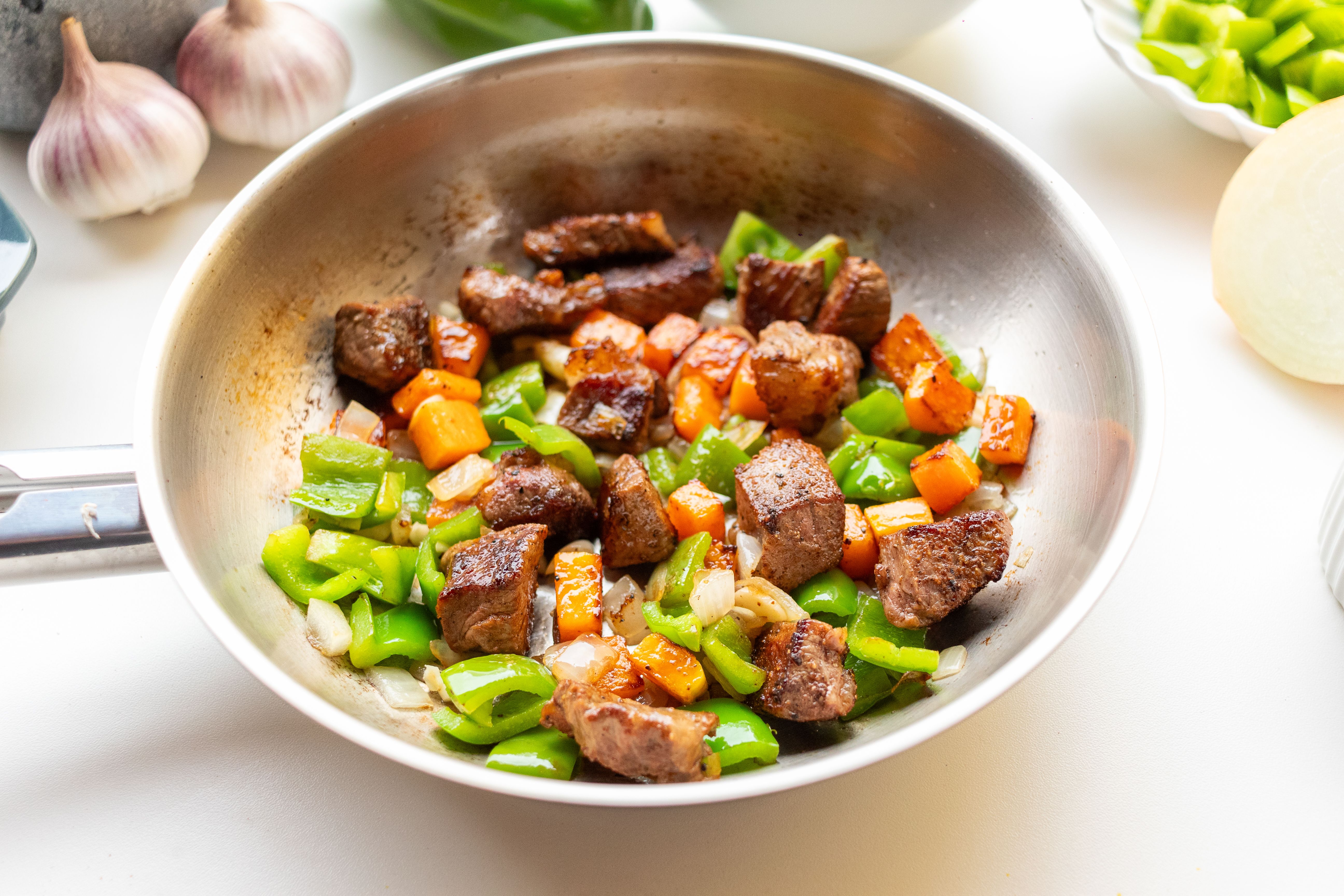 Salteado De Carne De Res Chisporroteante Con Verduras En Sartén Foto