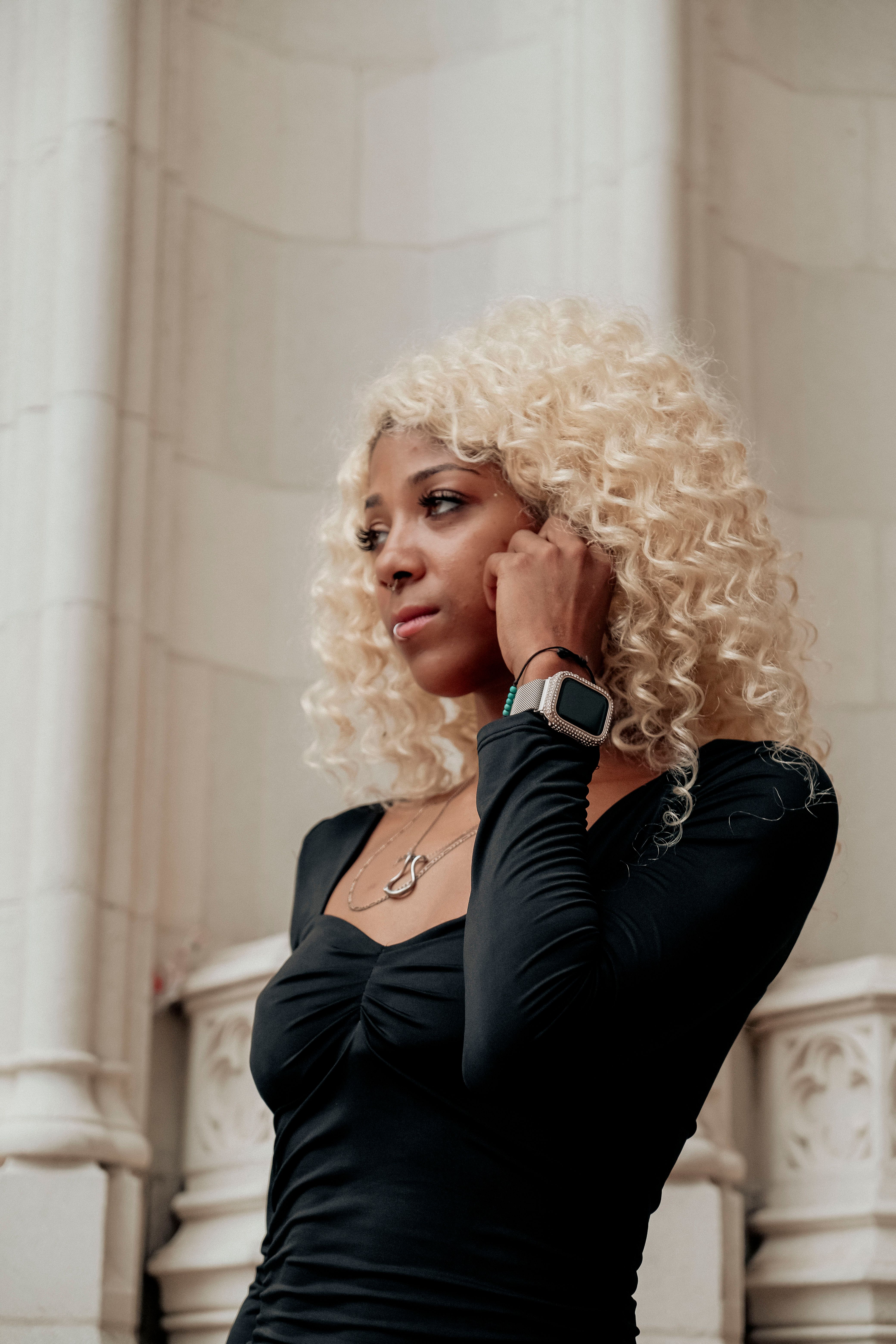 Elegant Woman with Curly Hair in Urban Setting · Free Stock Photo