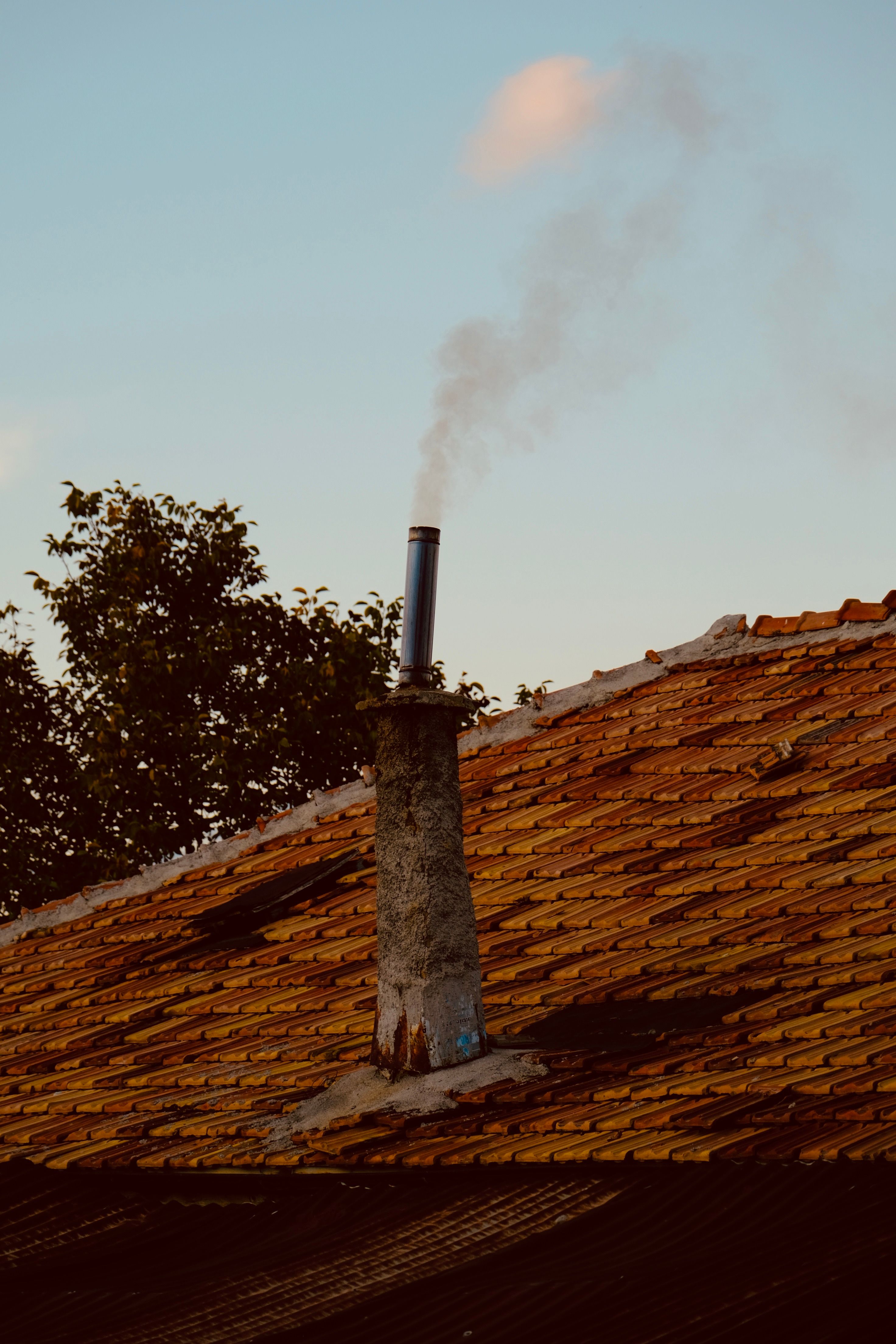 Old Rustic Chimney with Smoke on Tiled Roof · Free Stock Photo