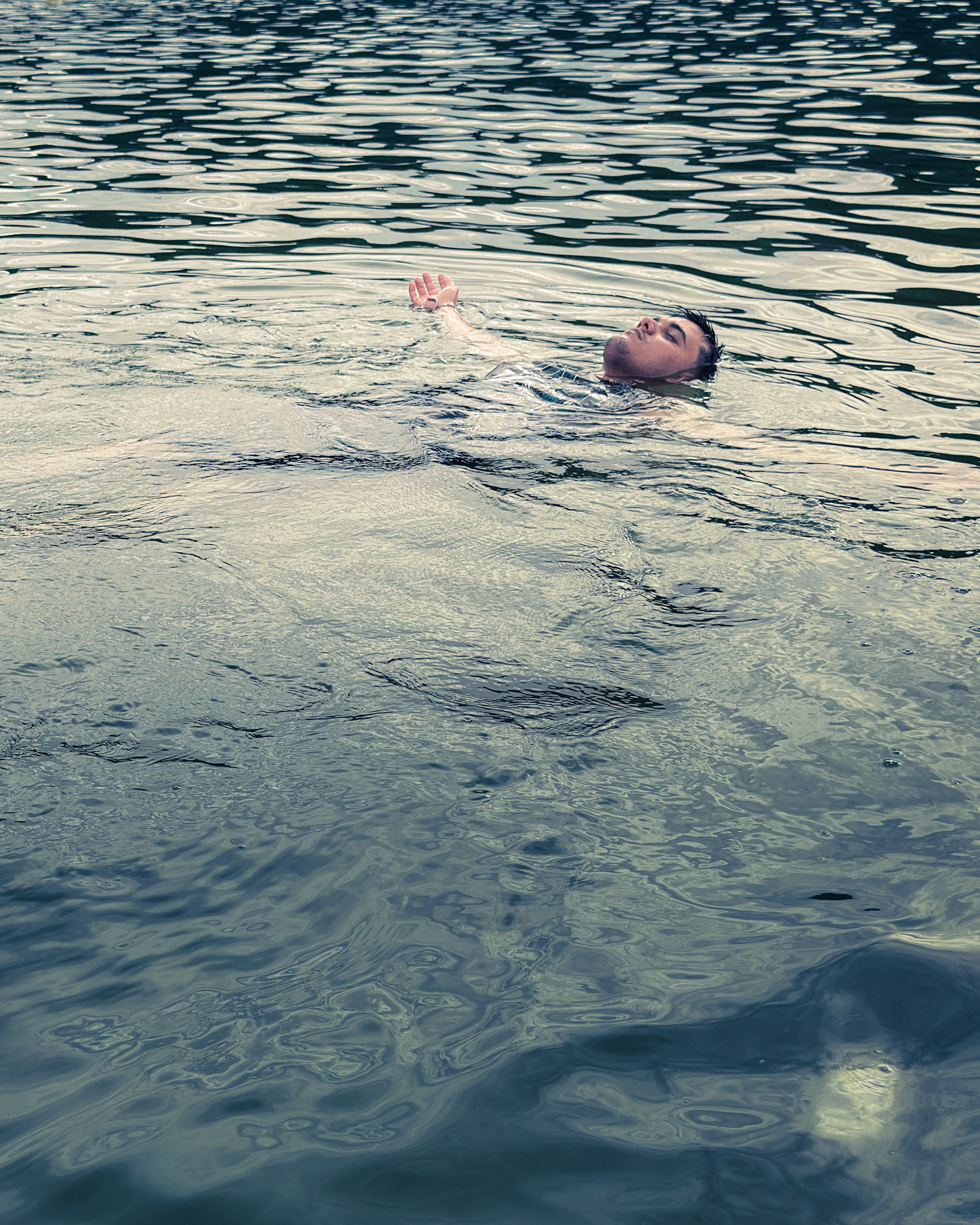 Serene Man Floating in Calm Lake Waters · Free Stock Photo