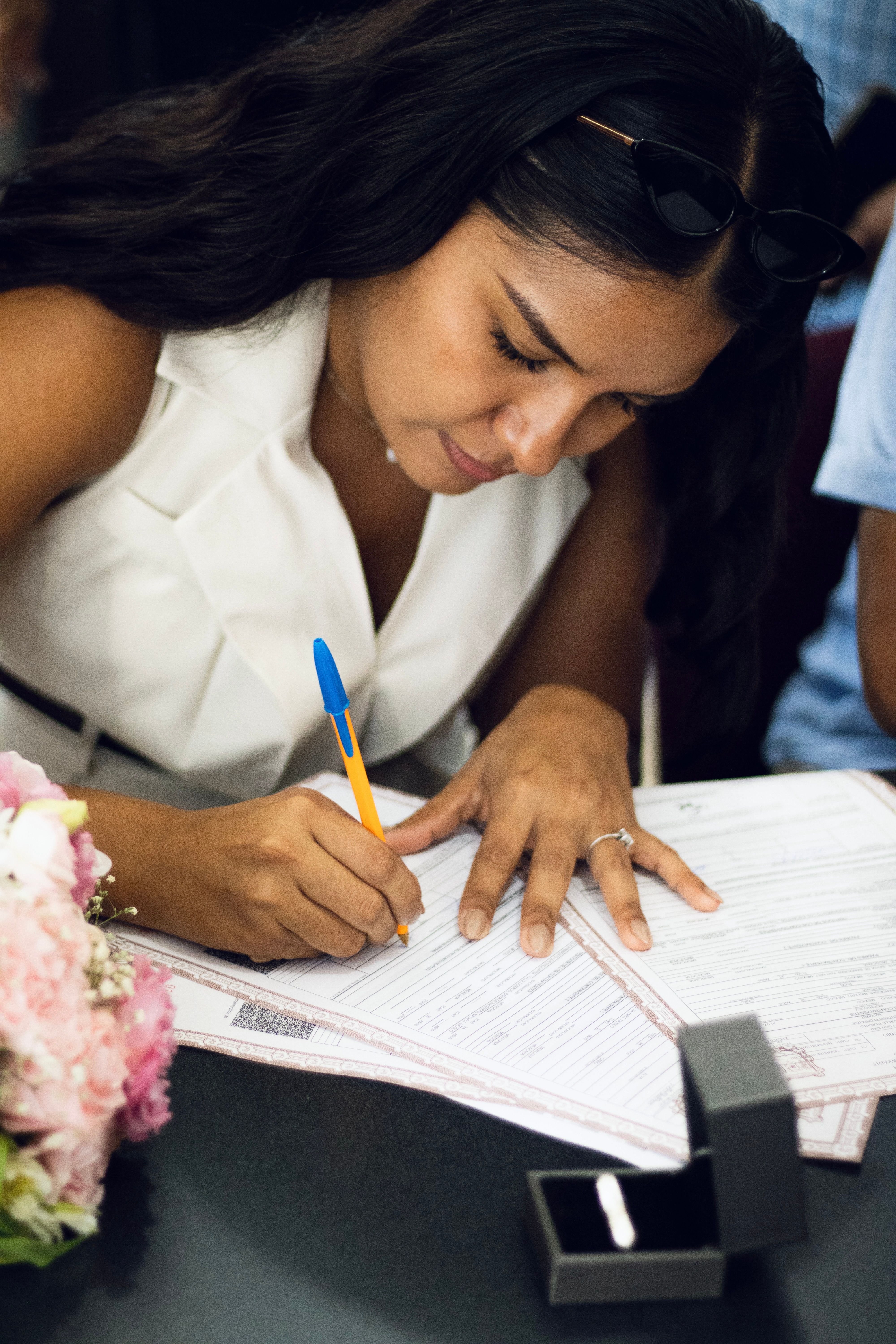 Young Woman Signing a Document at Wedding Ceremony · Free Stock Photo