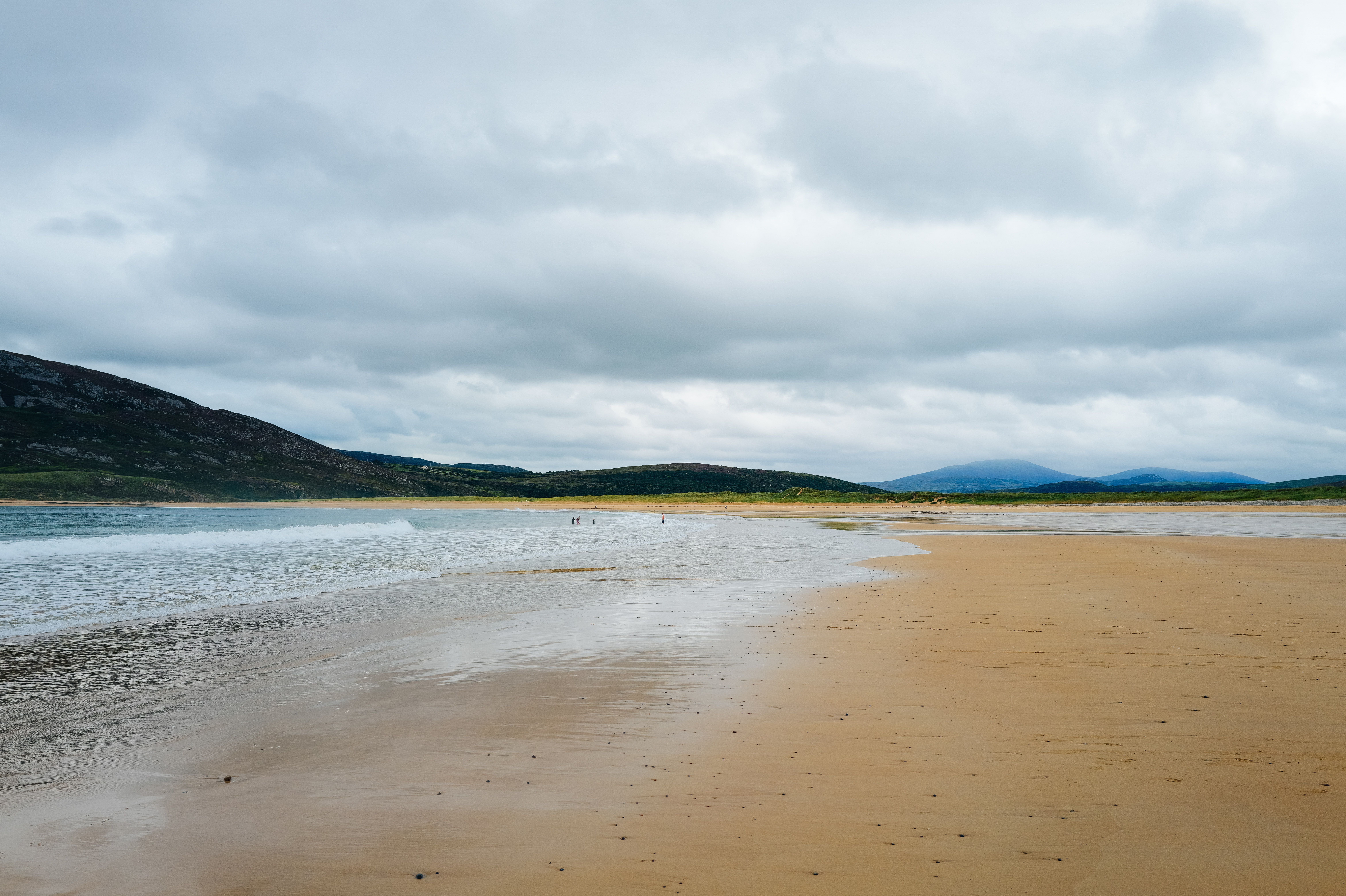 Serene Coastal Beach with Overcast Skies · Free Stock Photo