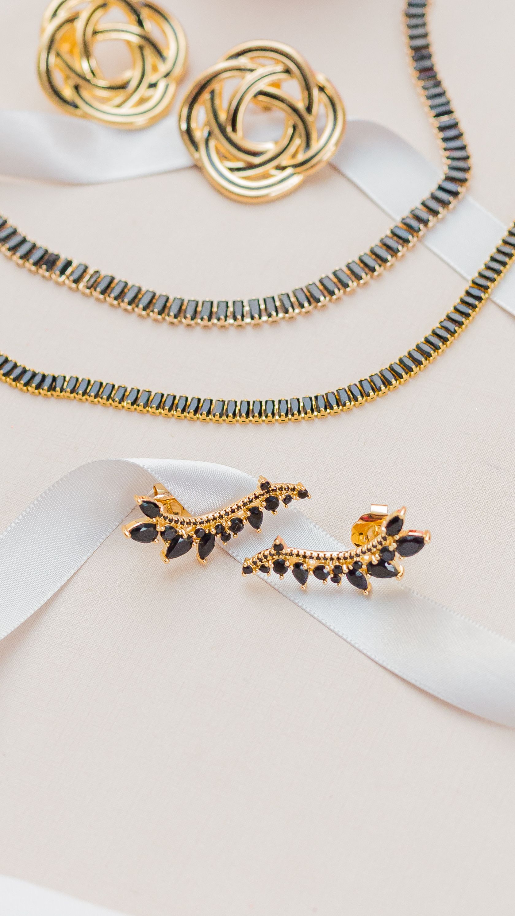 Elegant Gold Jewelry Set on White Ribbon · Free Stock Photo