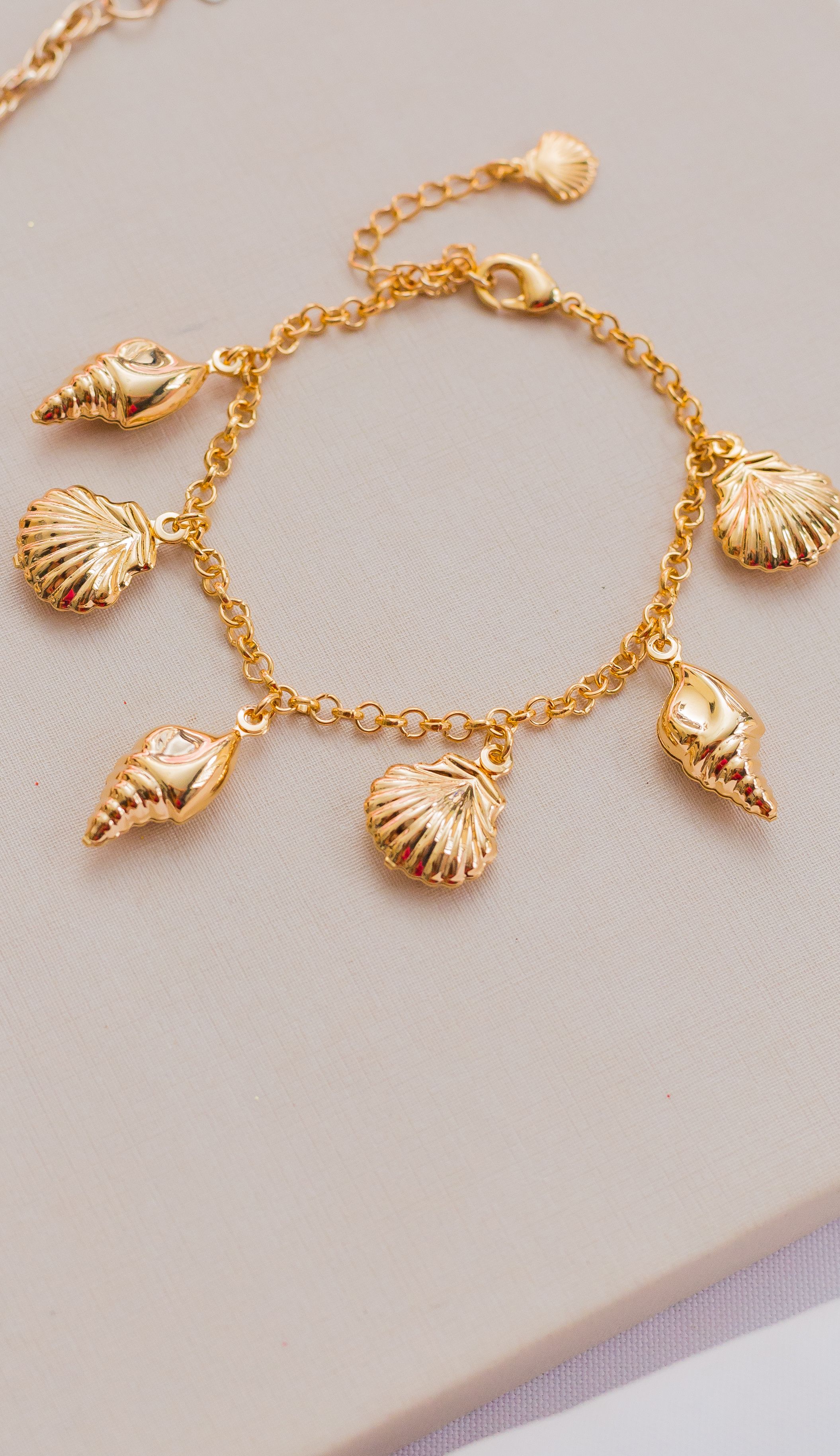Elegant Gold Seashell Bracelet on Neutral Background · Free Stock Photo