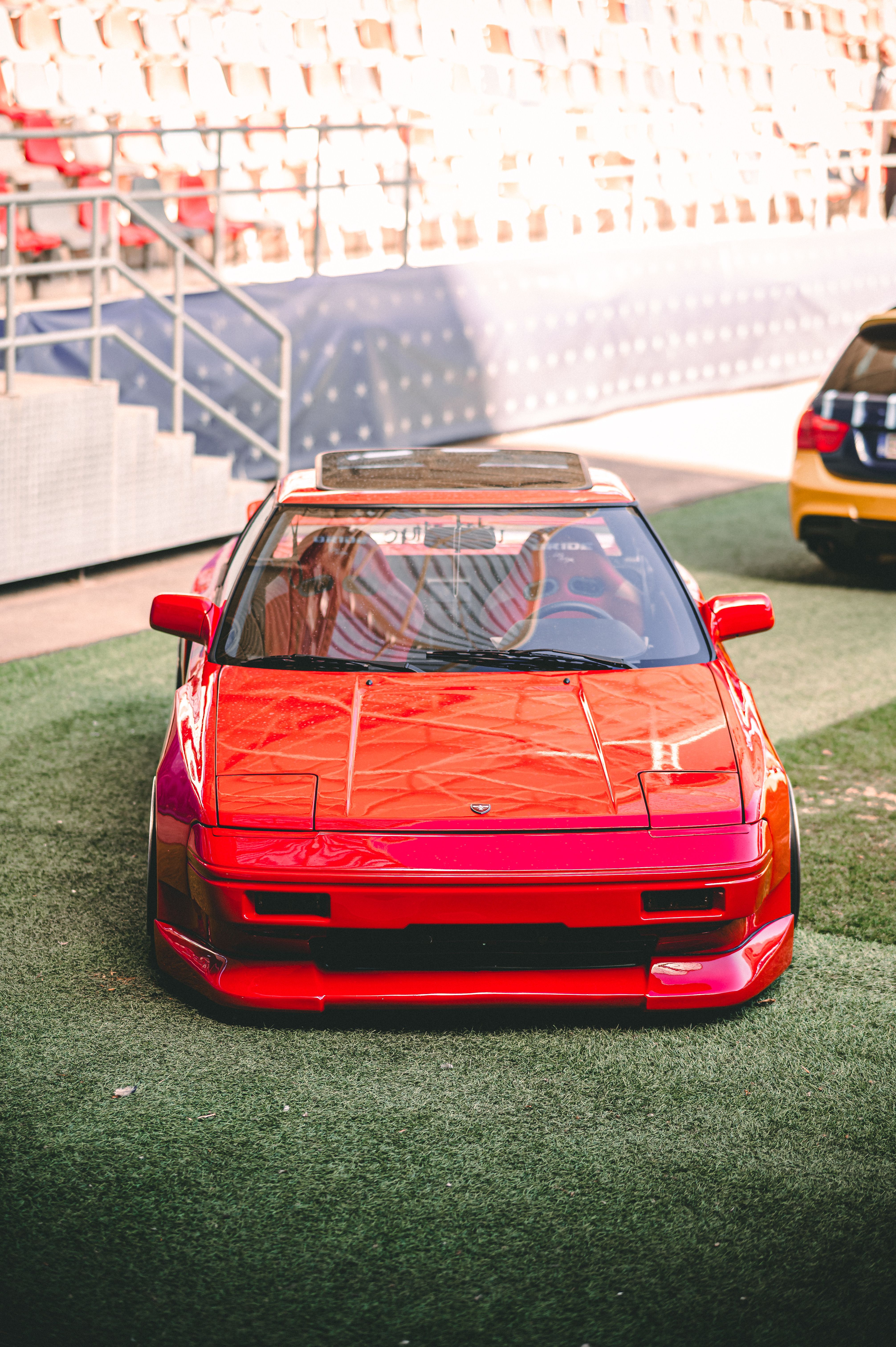 Red Sports Car Parked on Artificial Turf · Free Stock Photo