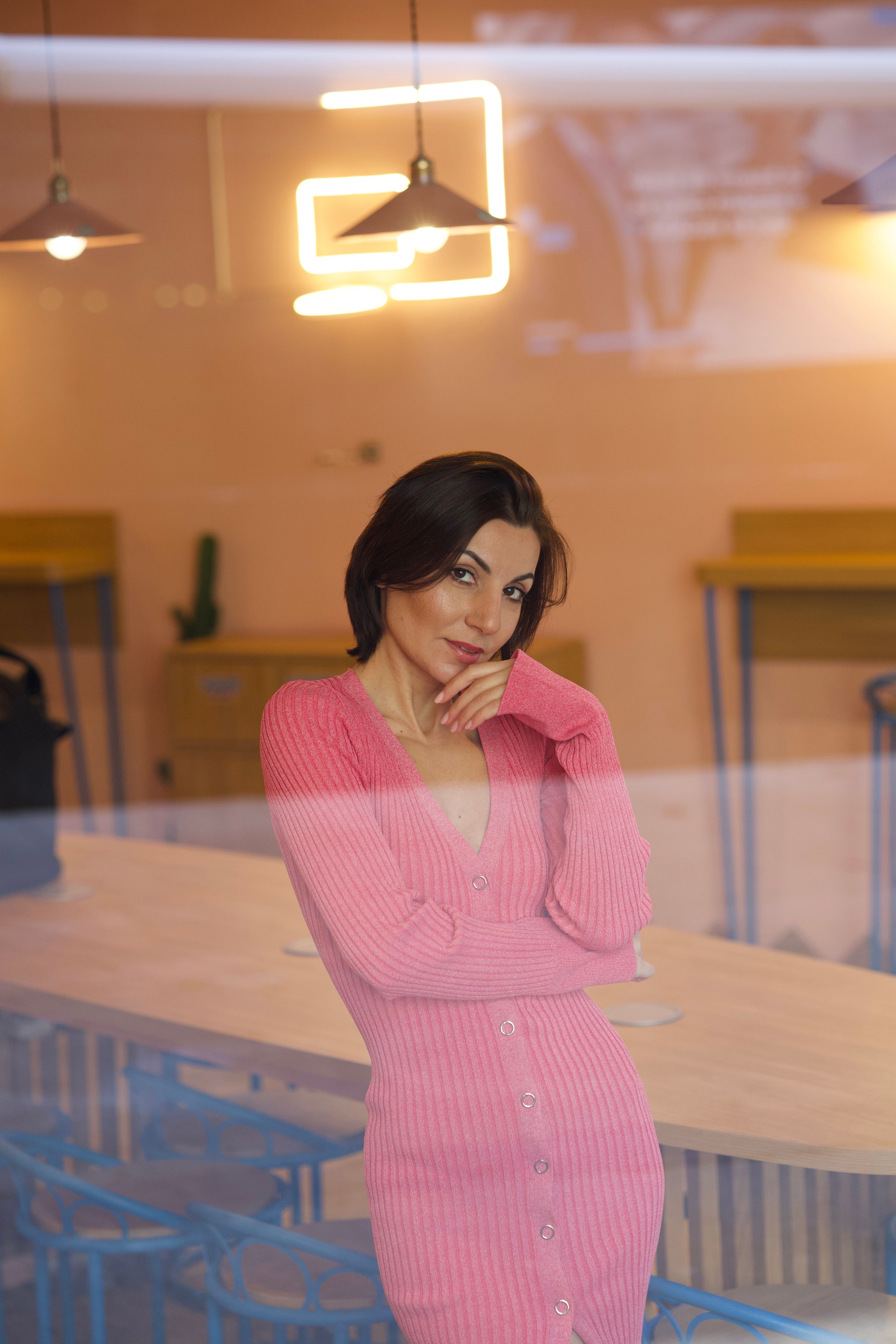 Woman in Pink Dress Posing Indoors by Table · Free Stock Photo