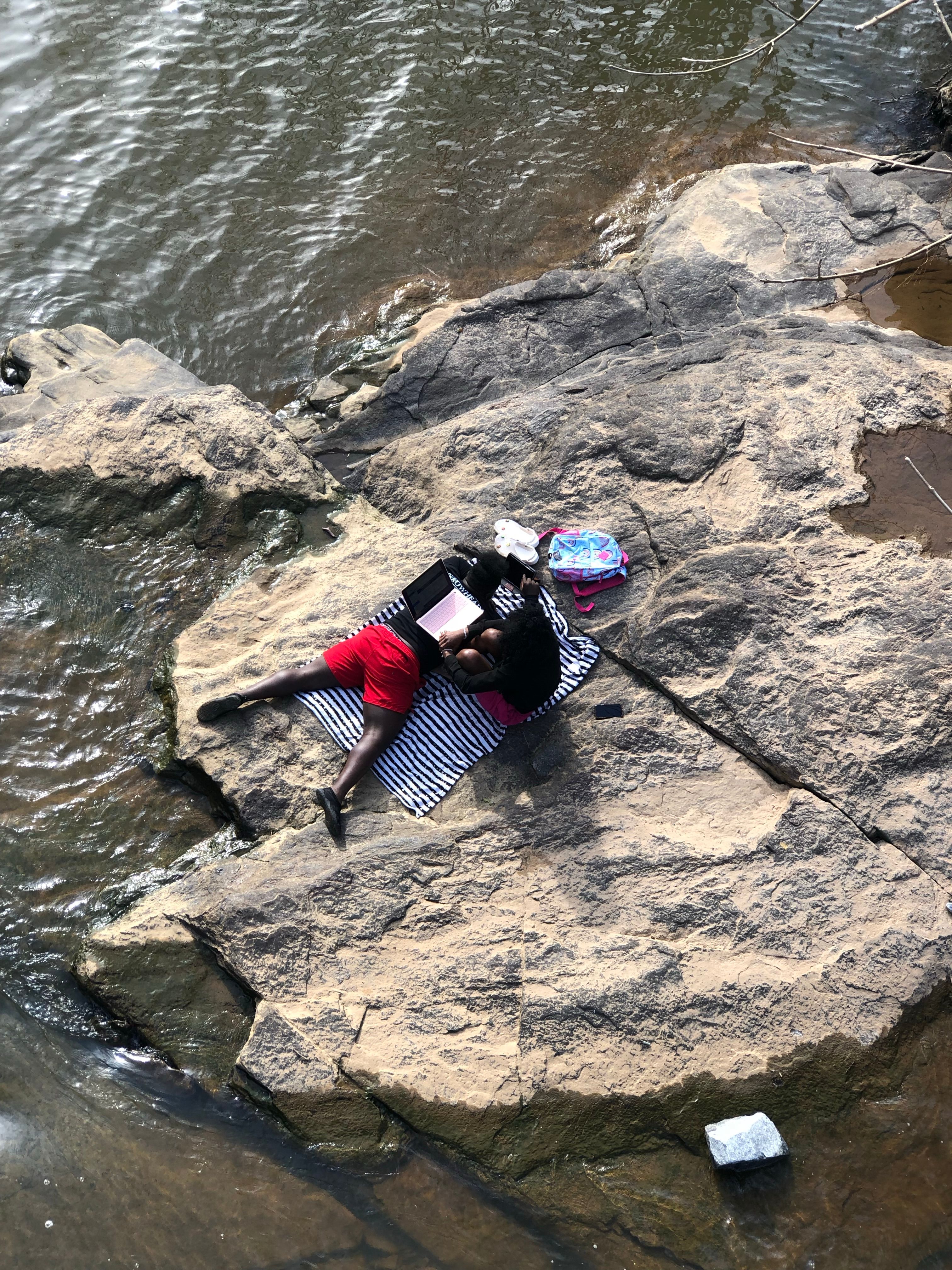 Couple Relaxing on Rocks by the River · Free Stock Photo