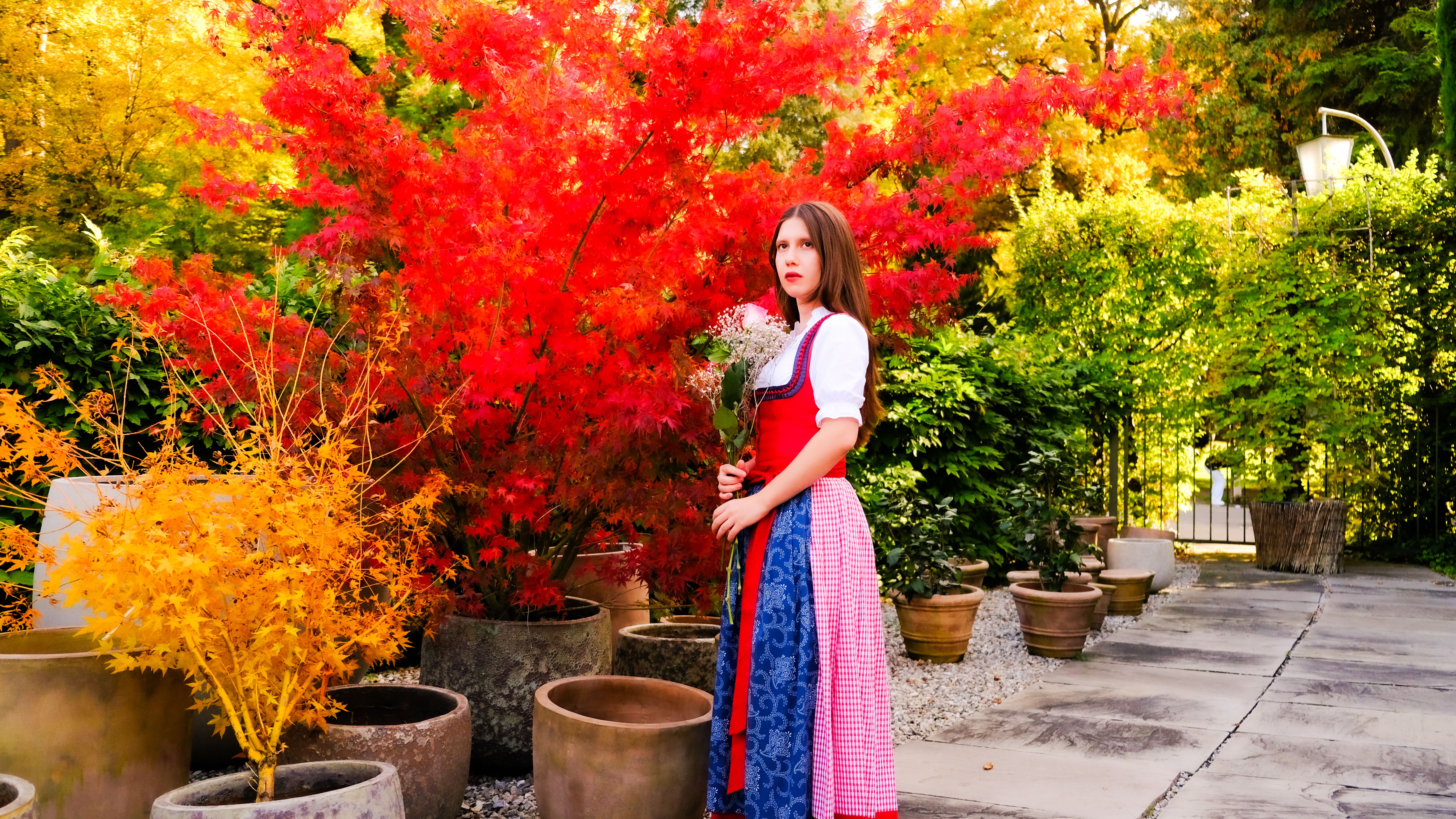 Traditional Austrian Attire in Vibrant Autumn Garden · Free Stock Photo