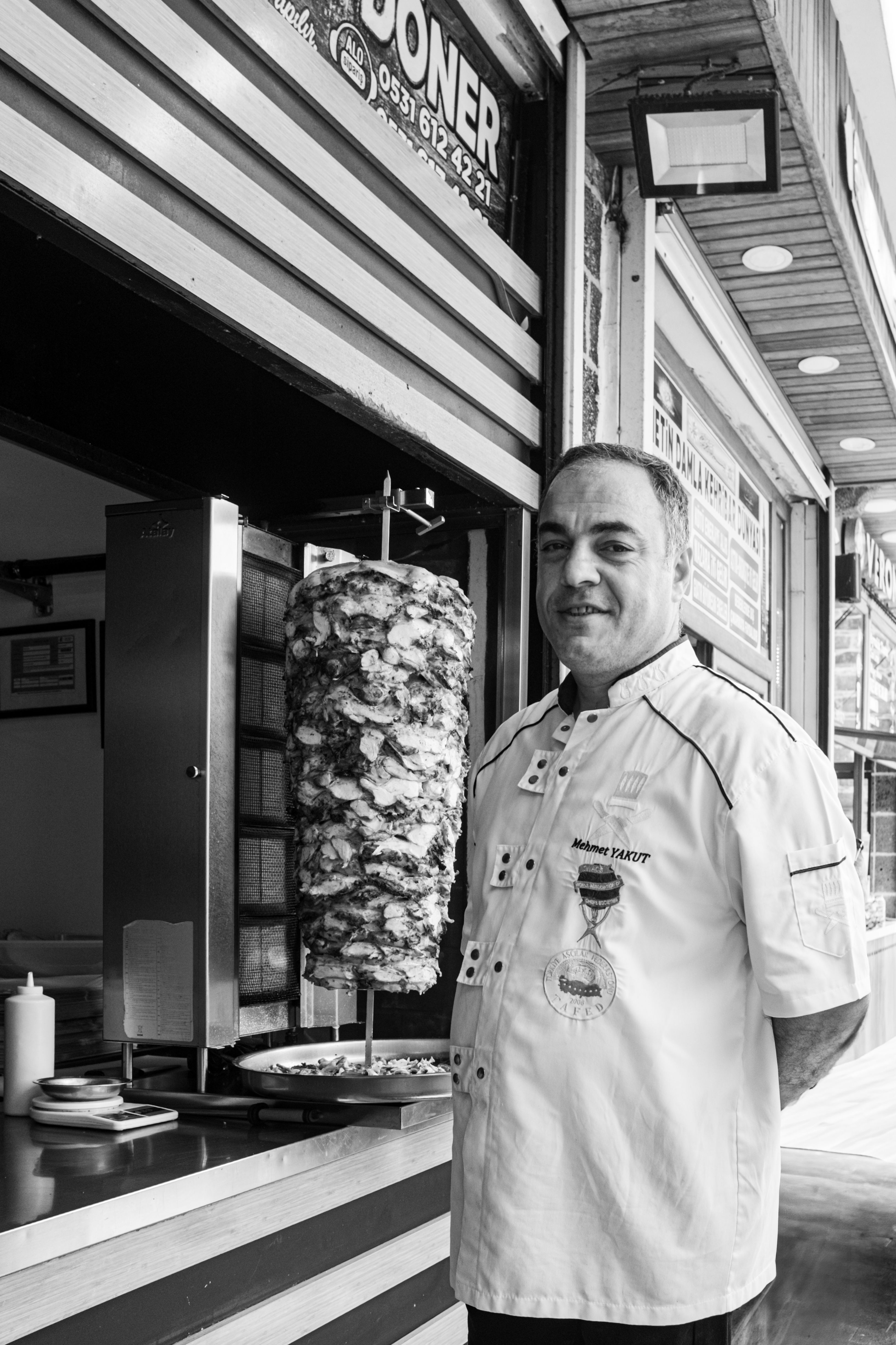 Chef Standing Next to a Rotating Doner Kebab Stand · Free Stock Photo