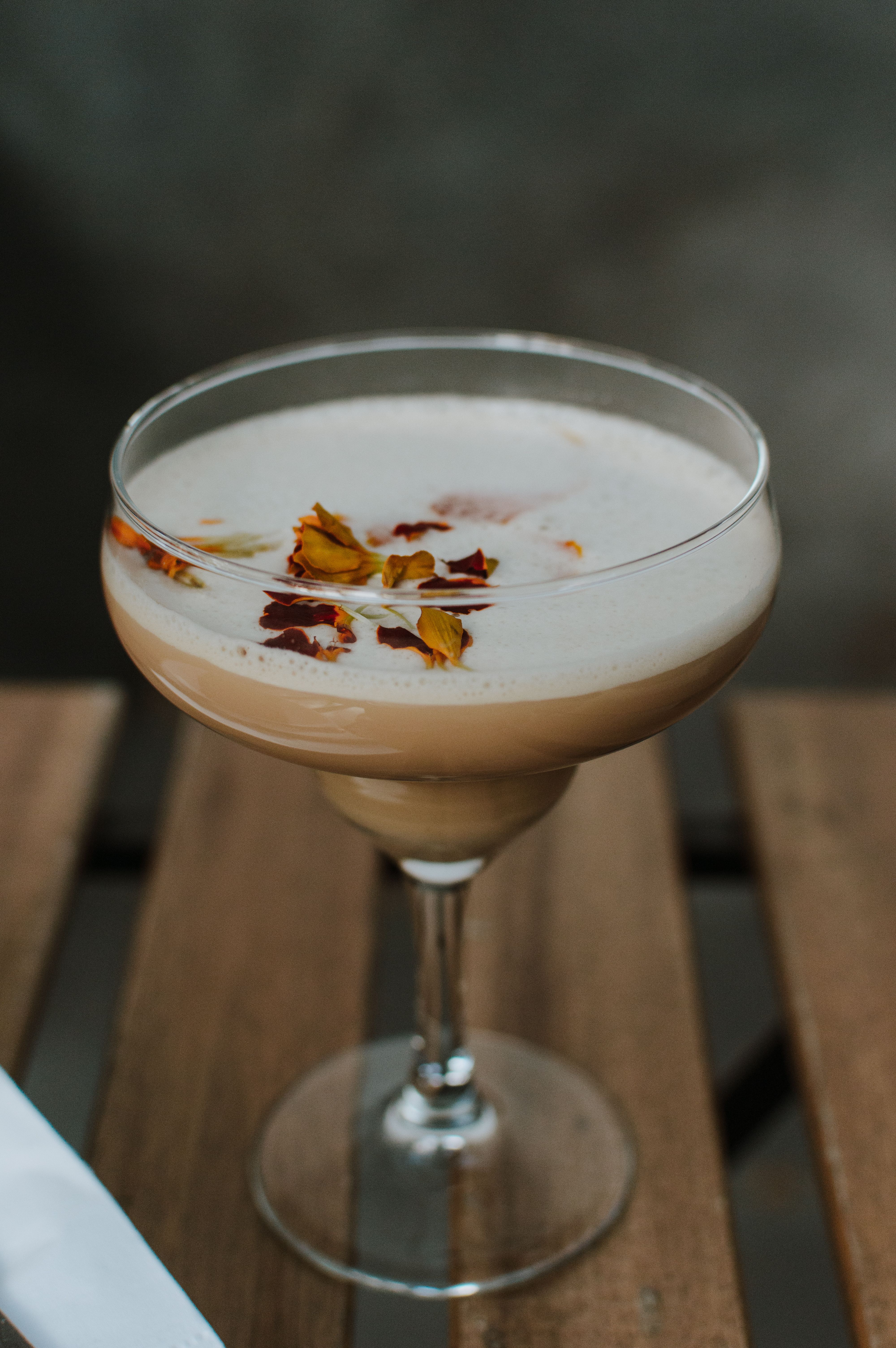 Elegant Latte with Marigold Petals on Rustic Table · Free Stock Photo