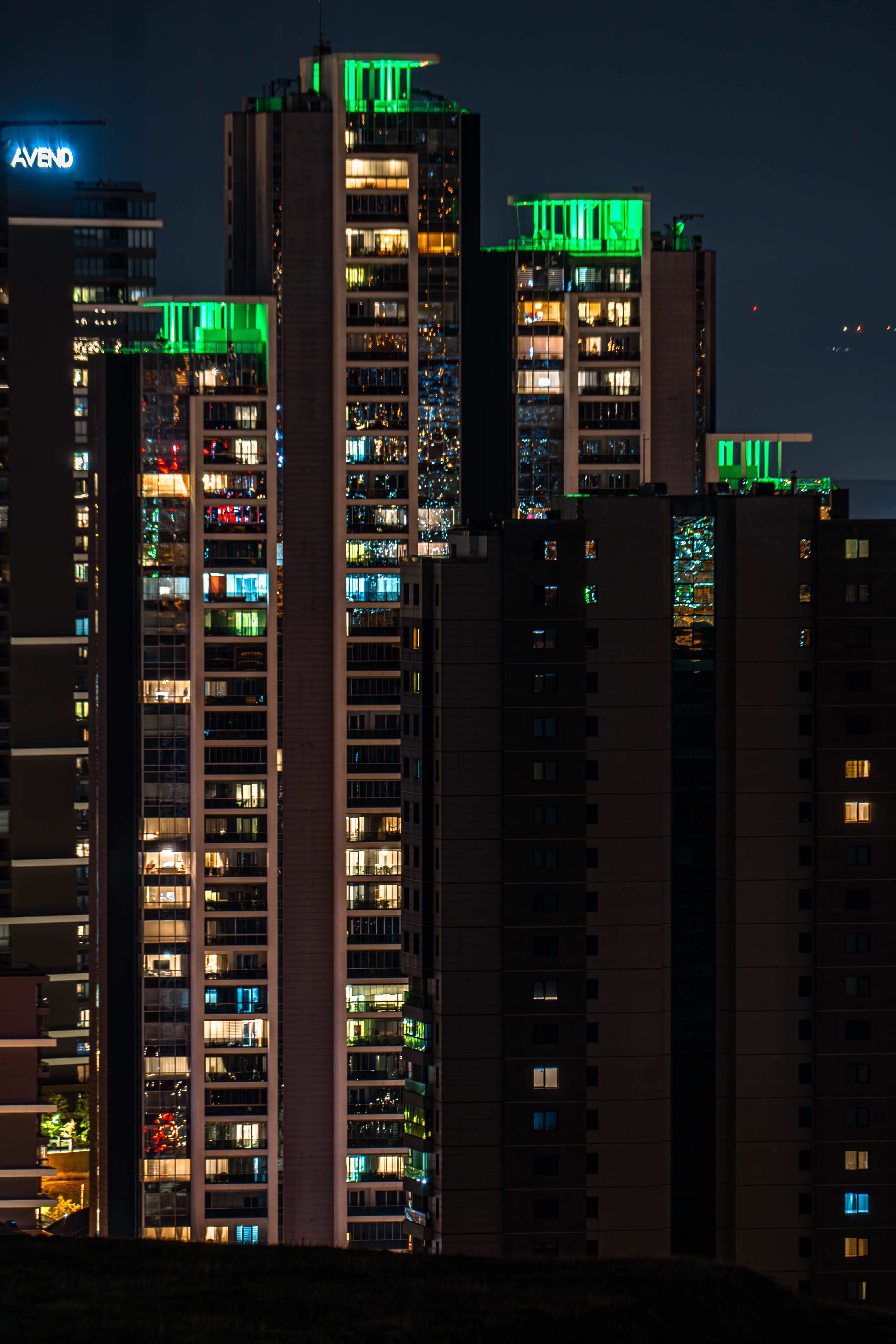 Modern High-Rise Buildings Illuminated at Night · Free Stock Photo