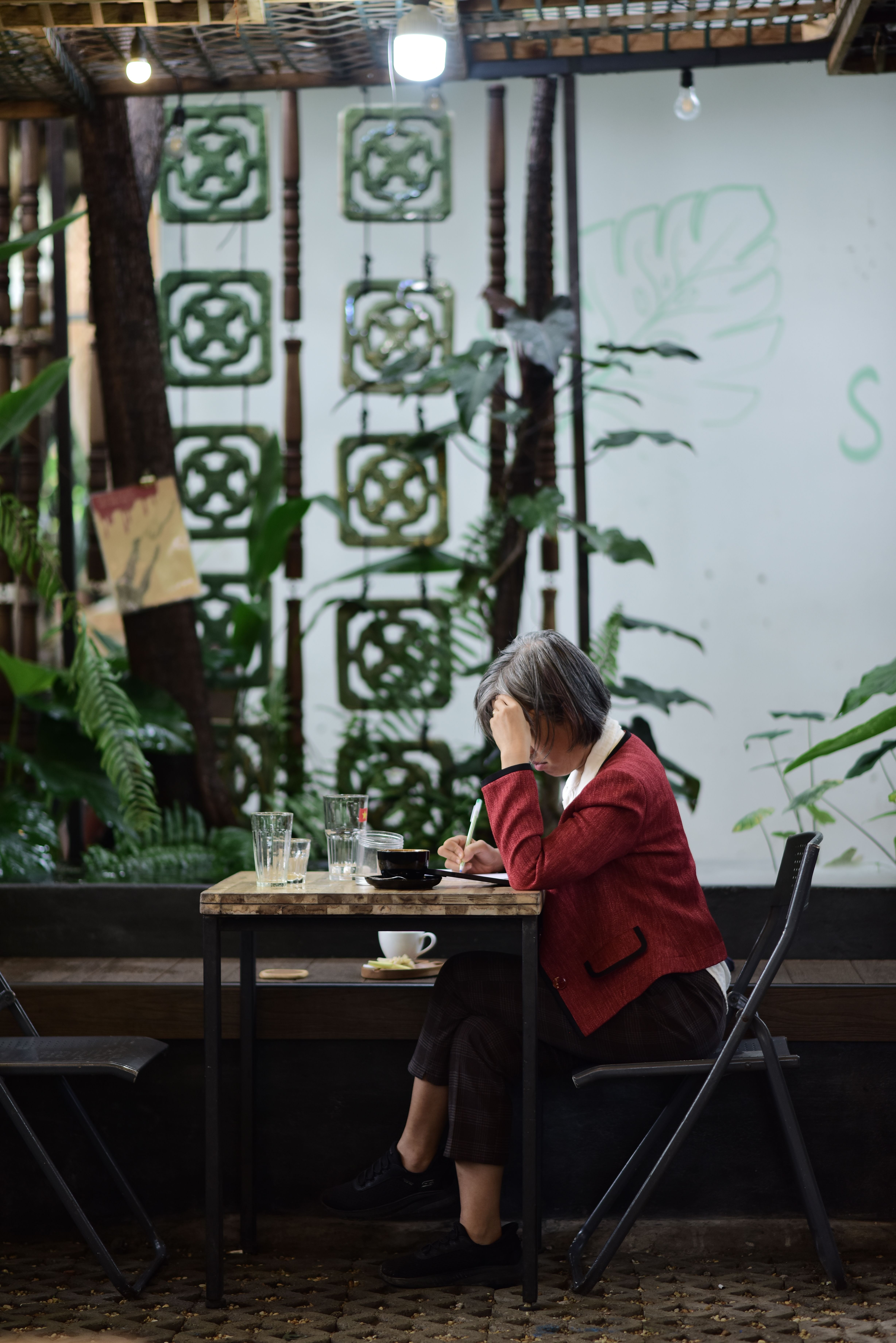 Senior Woman Writing in Cozy Outdoor Café · Free Stock Photo
