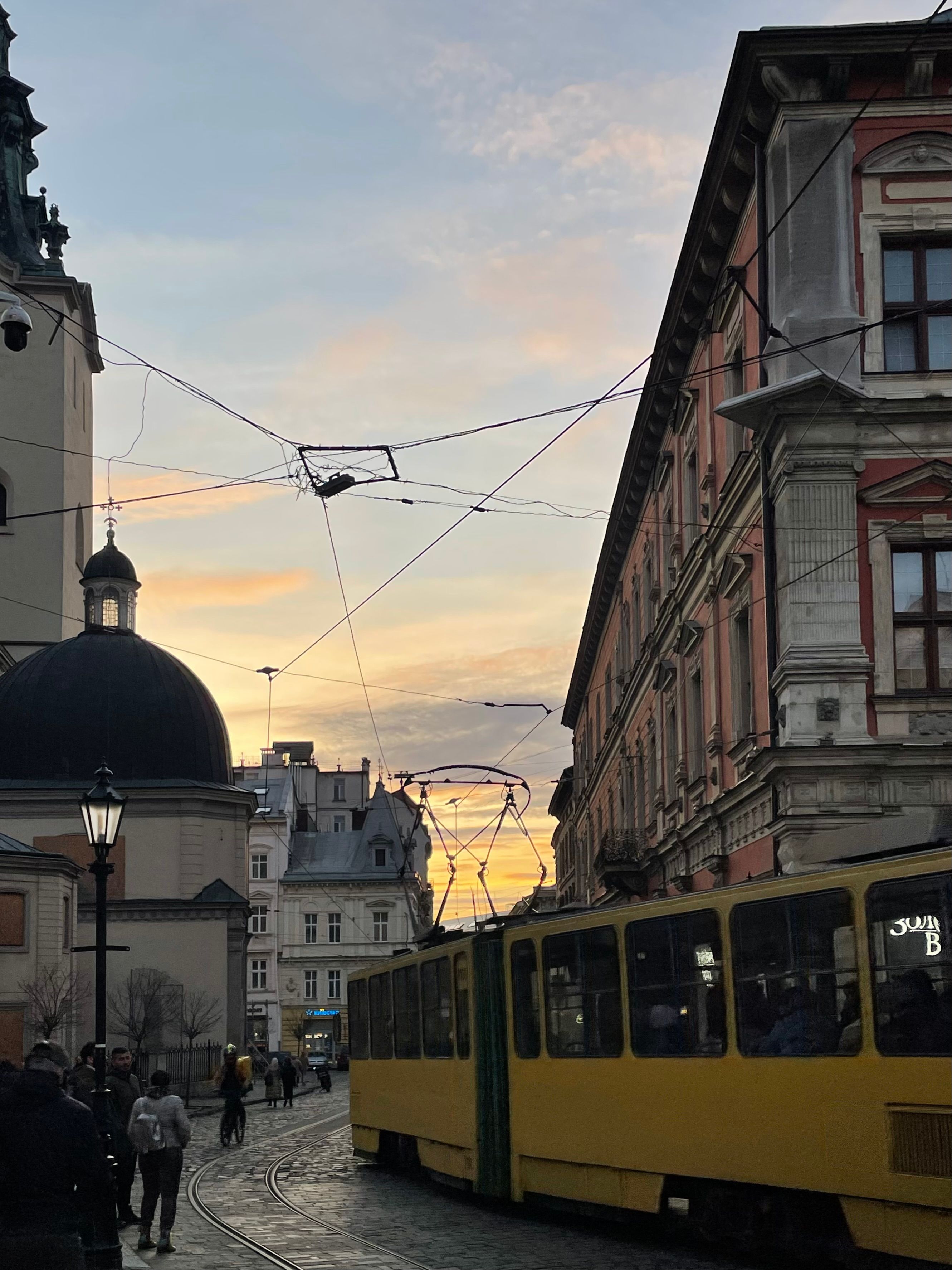 Evening Street Scene with Tram and Historical Buildings · Free Stock Photo