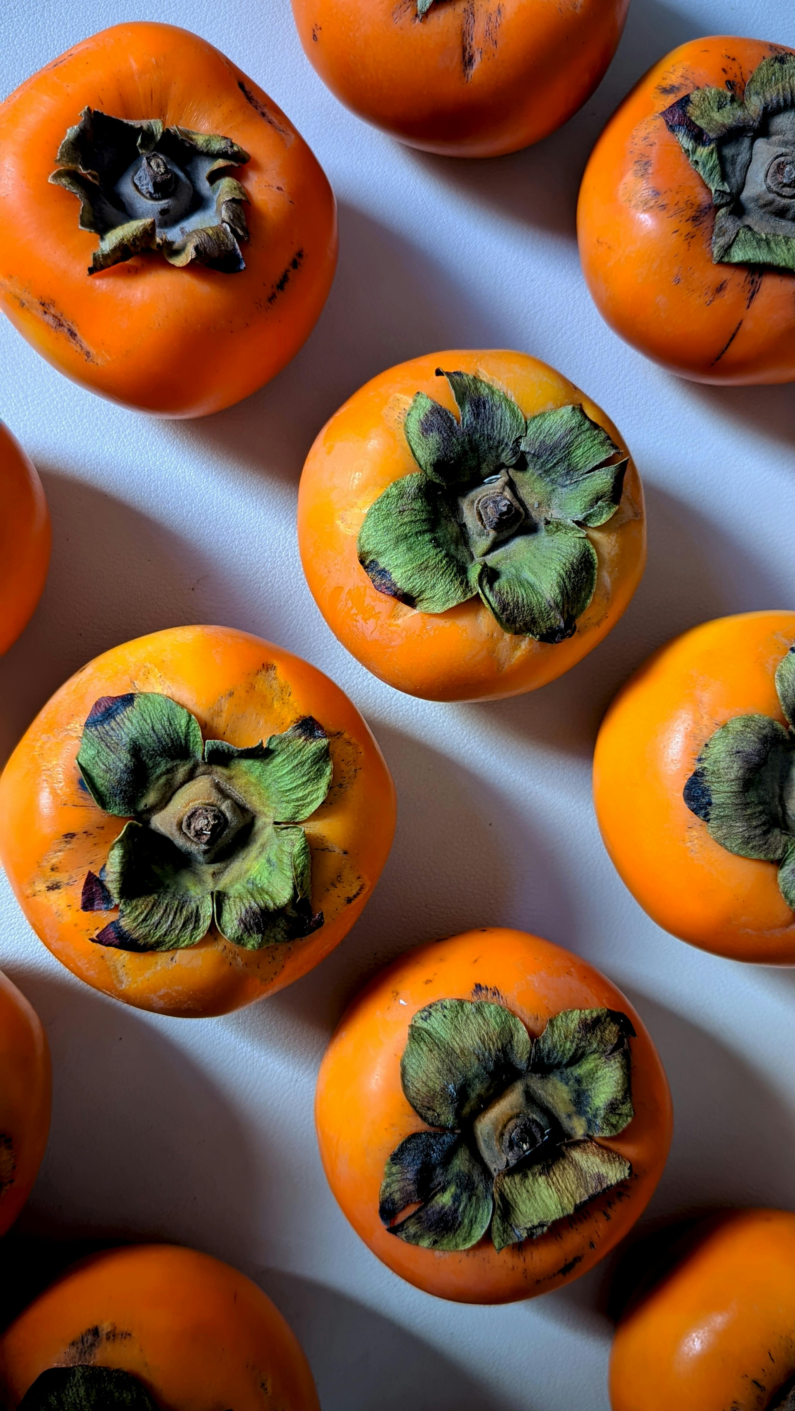 Fresh Persimmons on a Light Background · Free Stock Photo