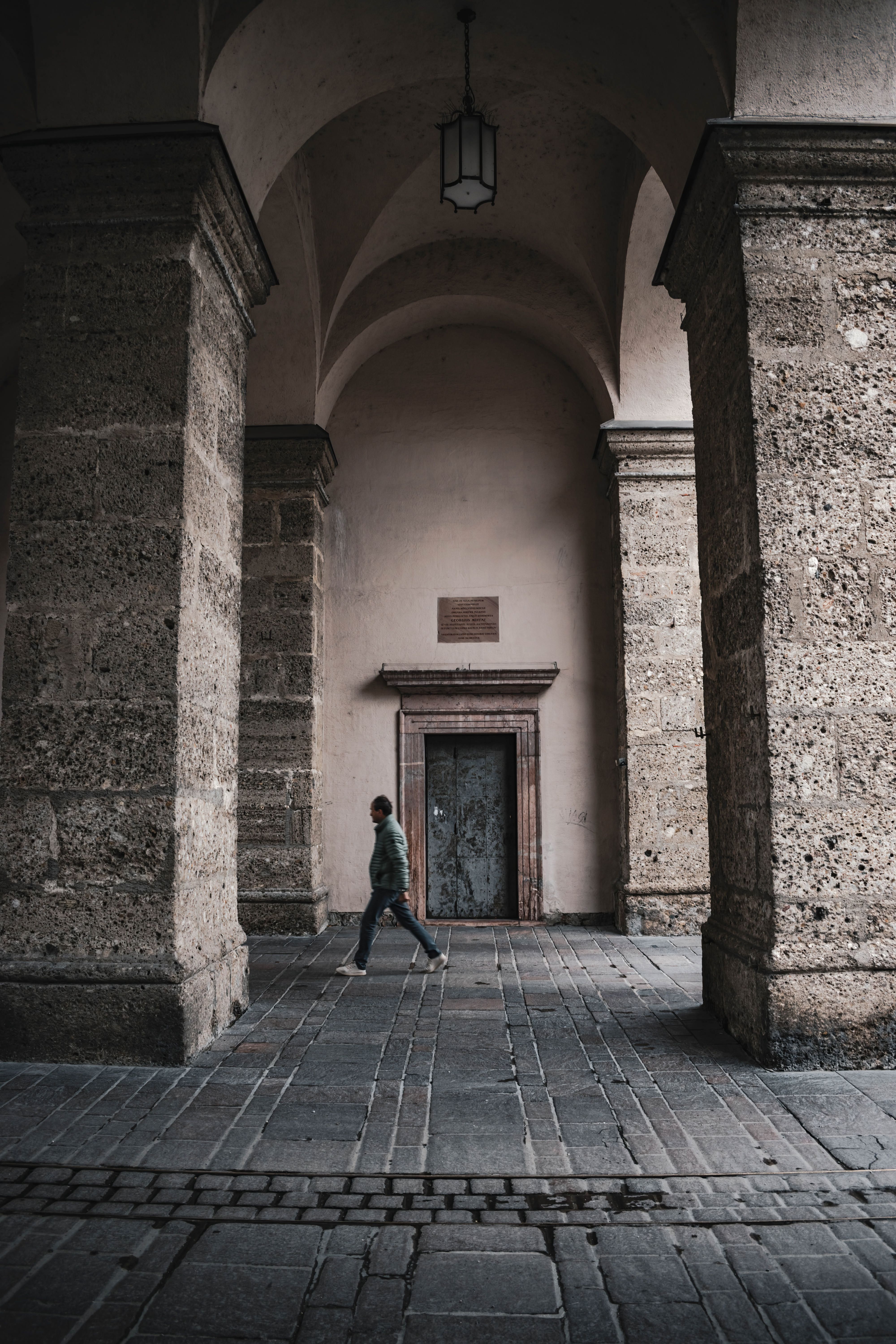Person Walking Under Arched Passage in Salzburg · Free Stock Photo