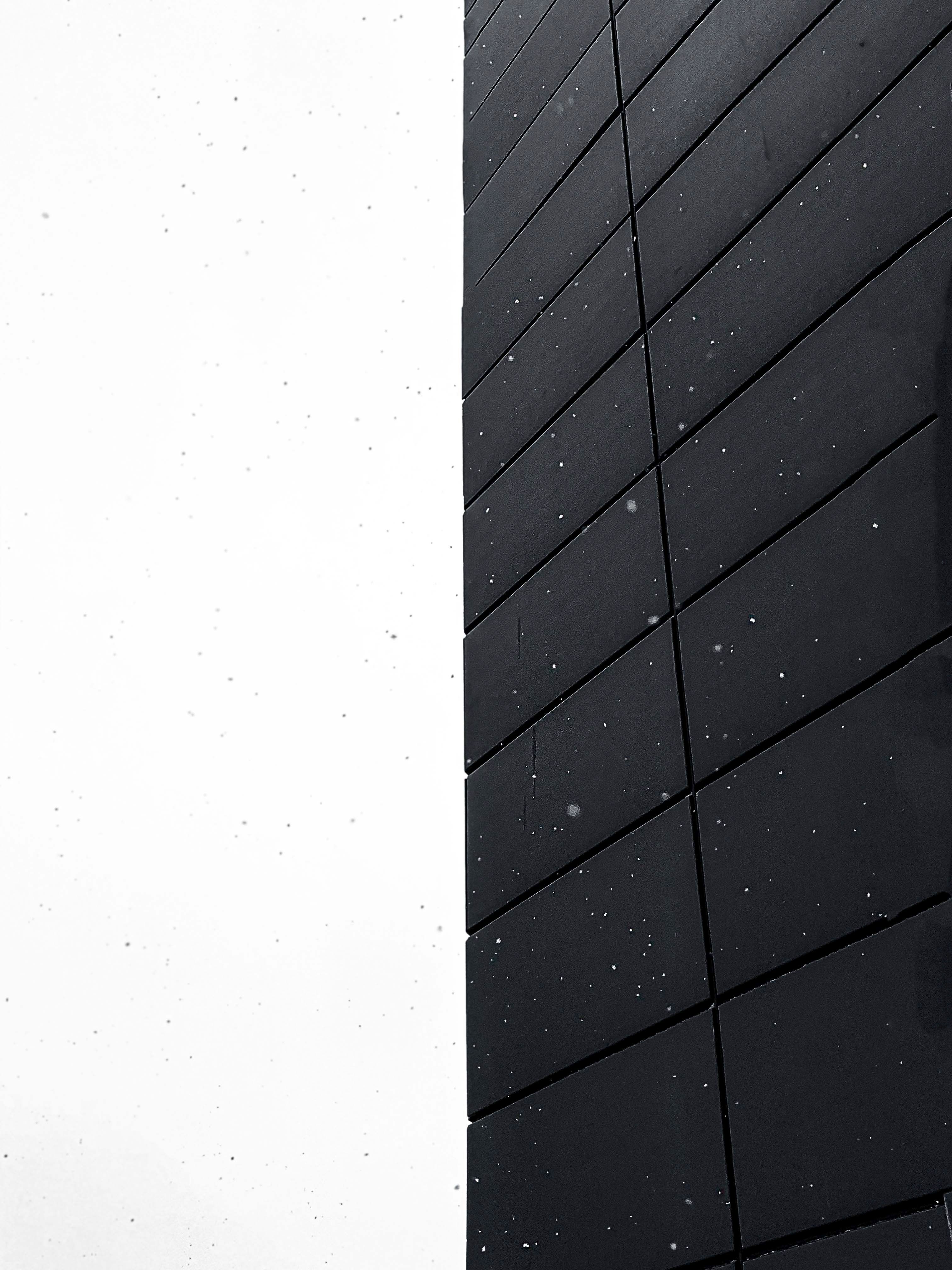 Tiled black wall of modern building against white sky · Free Stock Photo
