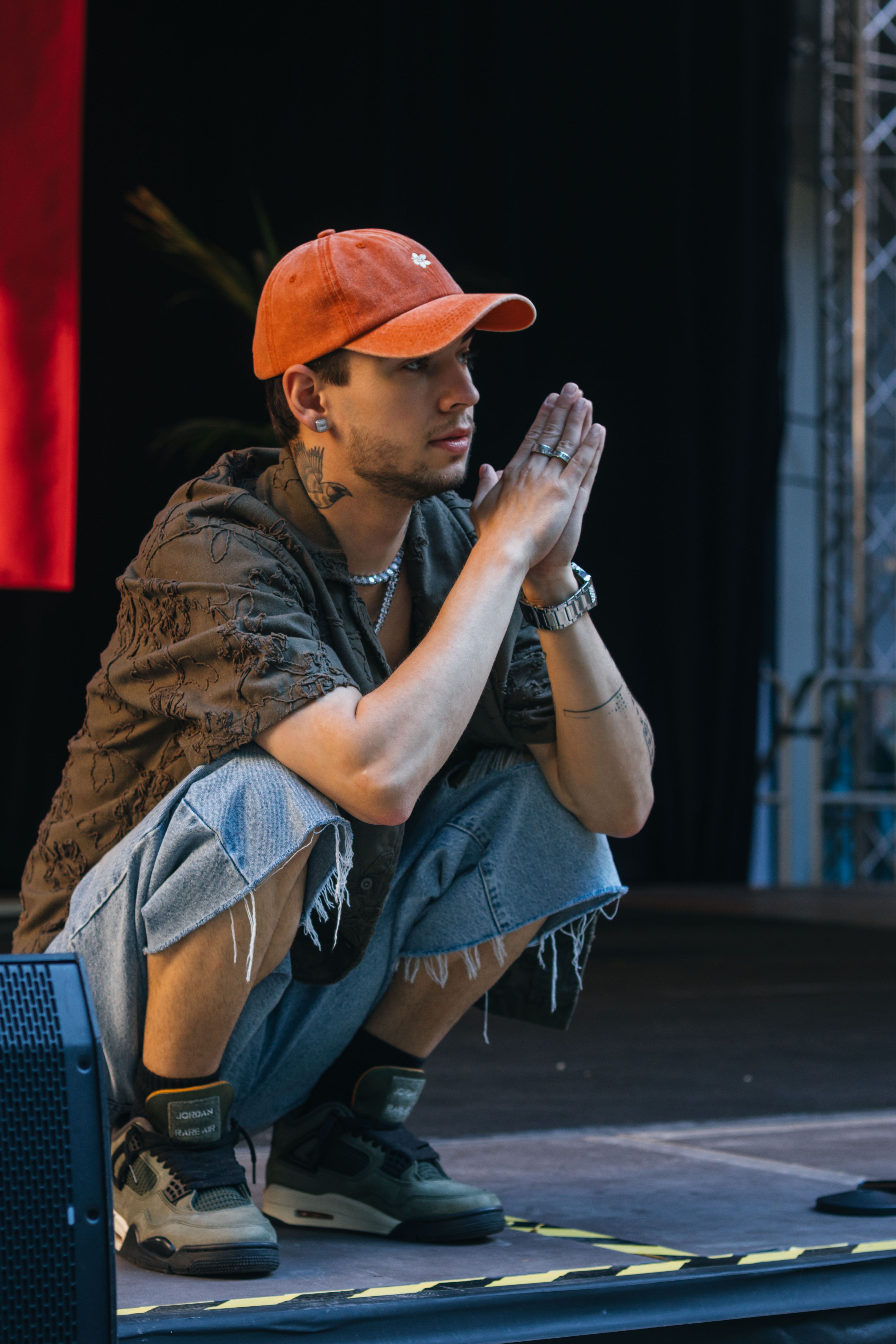 Fashionable Young Man Squatting on Stage · Free Stock Photo