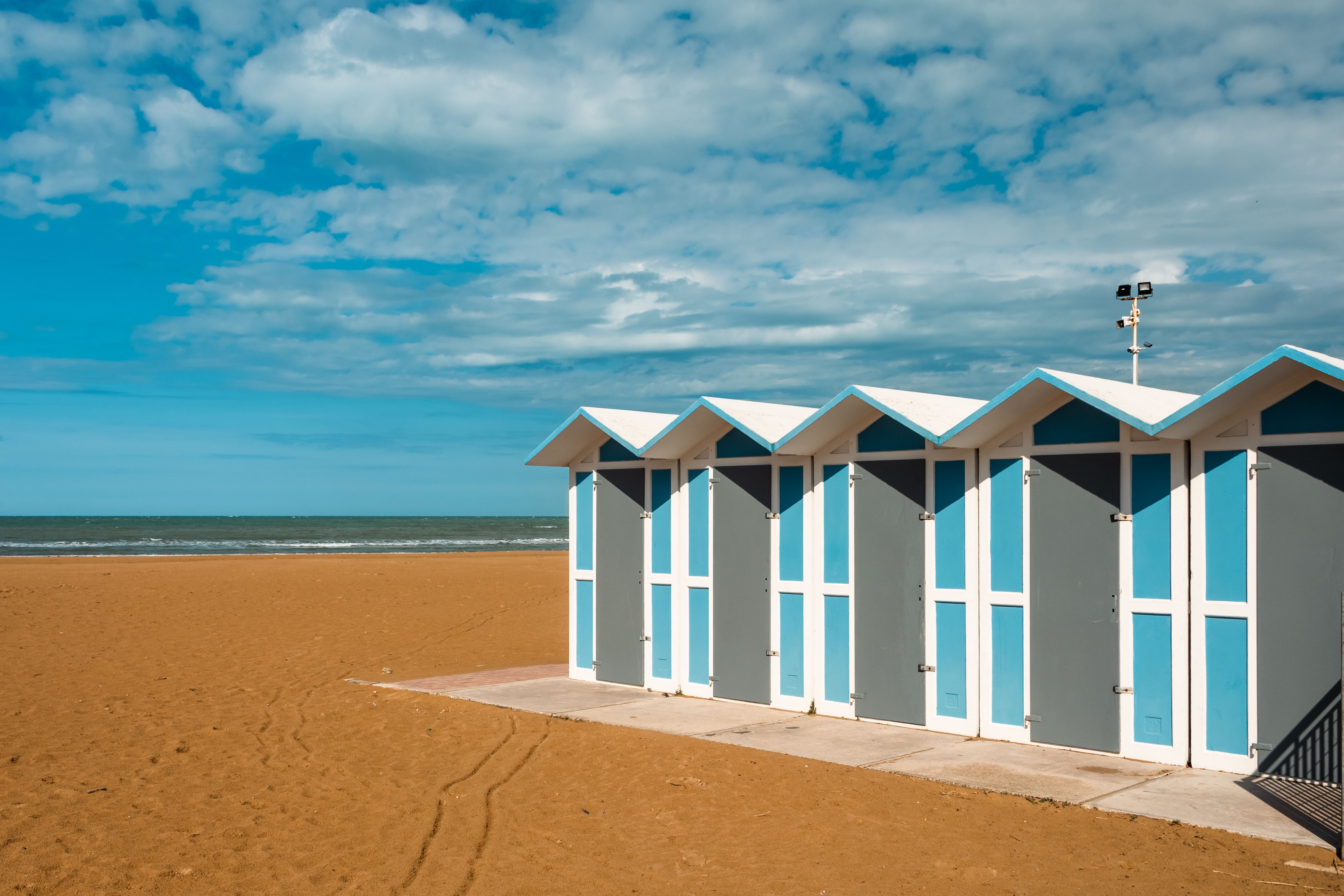 Charming Beachfront Blue and White Cabins · Free Stock Photo