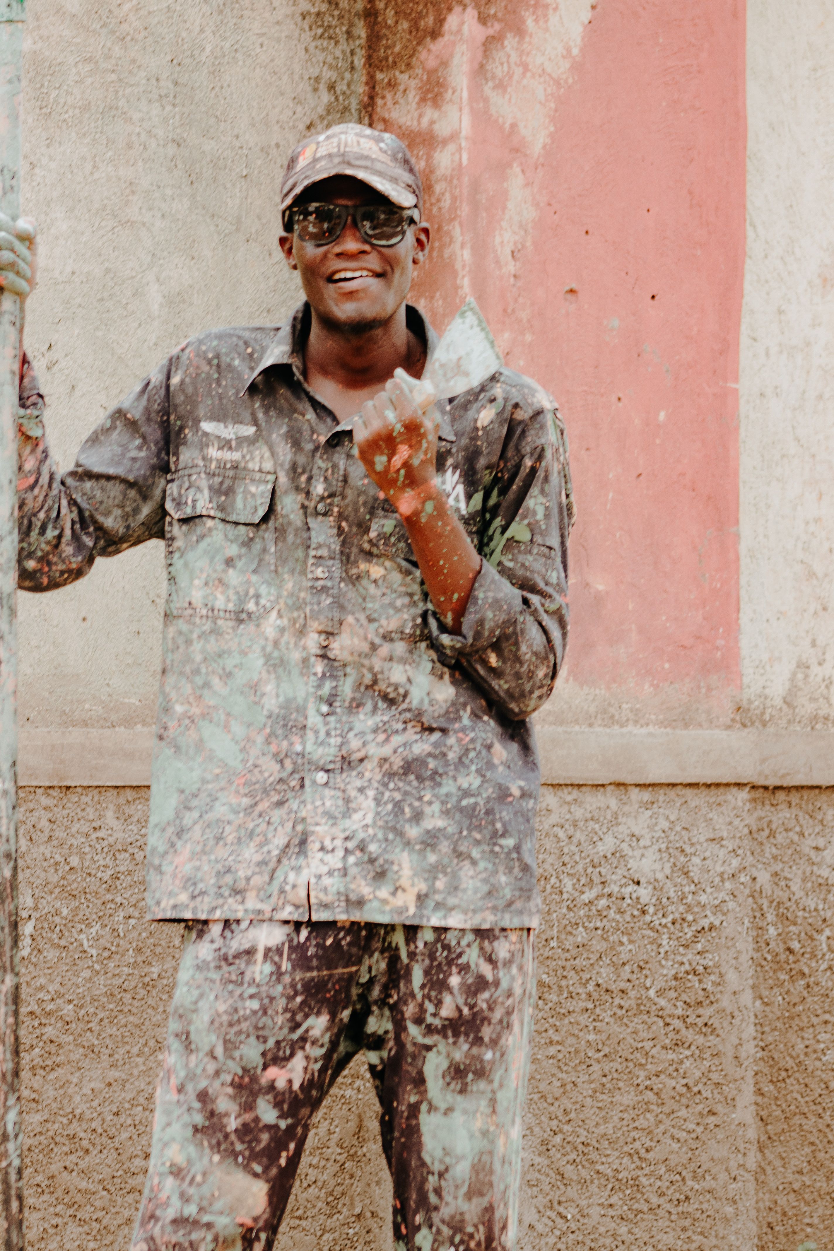 Smiling Painter Covered in Paint Standing Outside · Free Stock Photo
