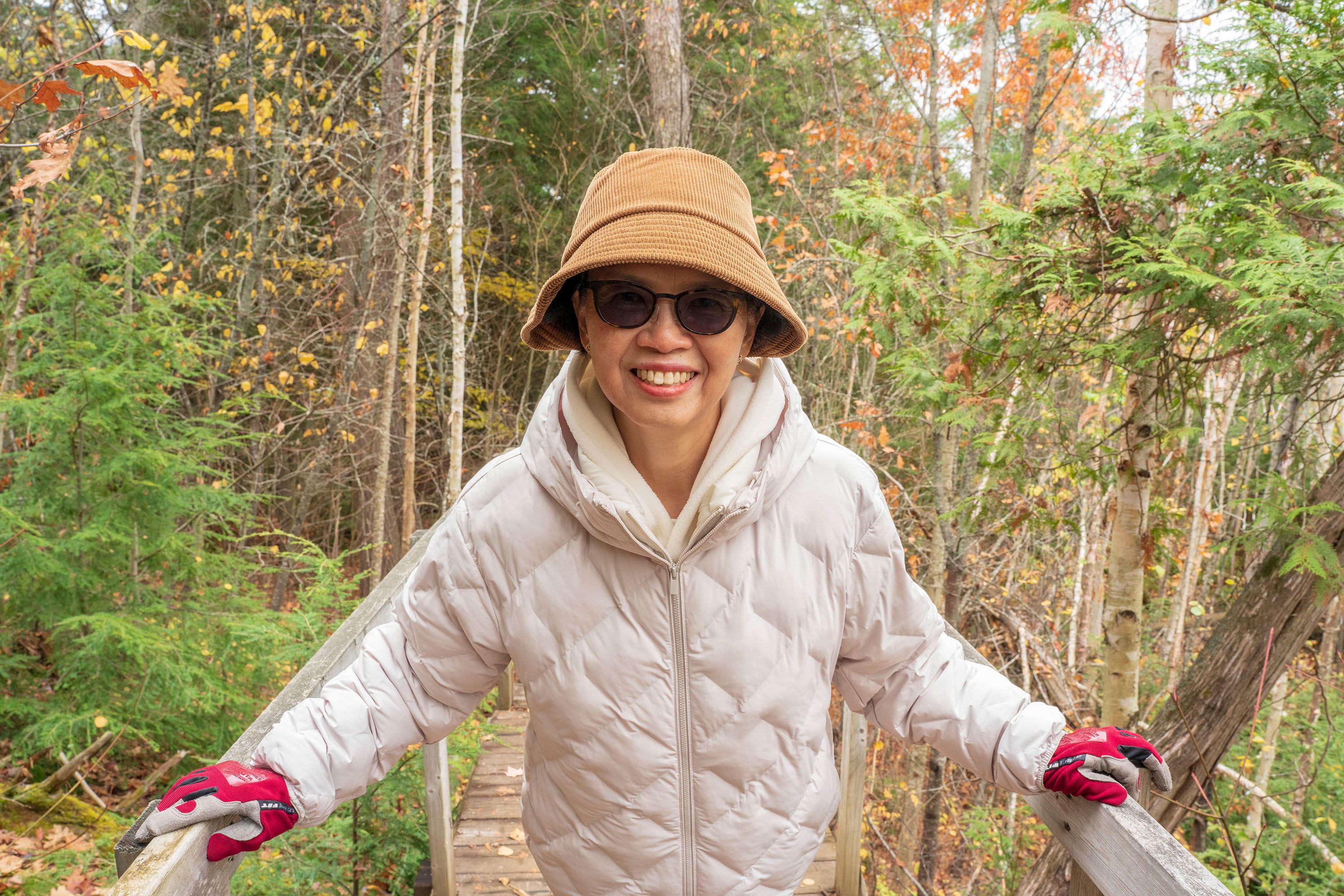 Smiling Woman on Forest Boardwalk in Fall · Free Stock Photo