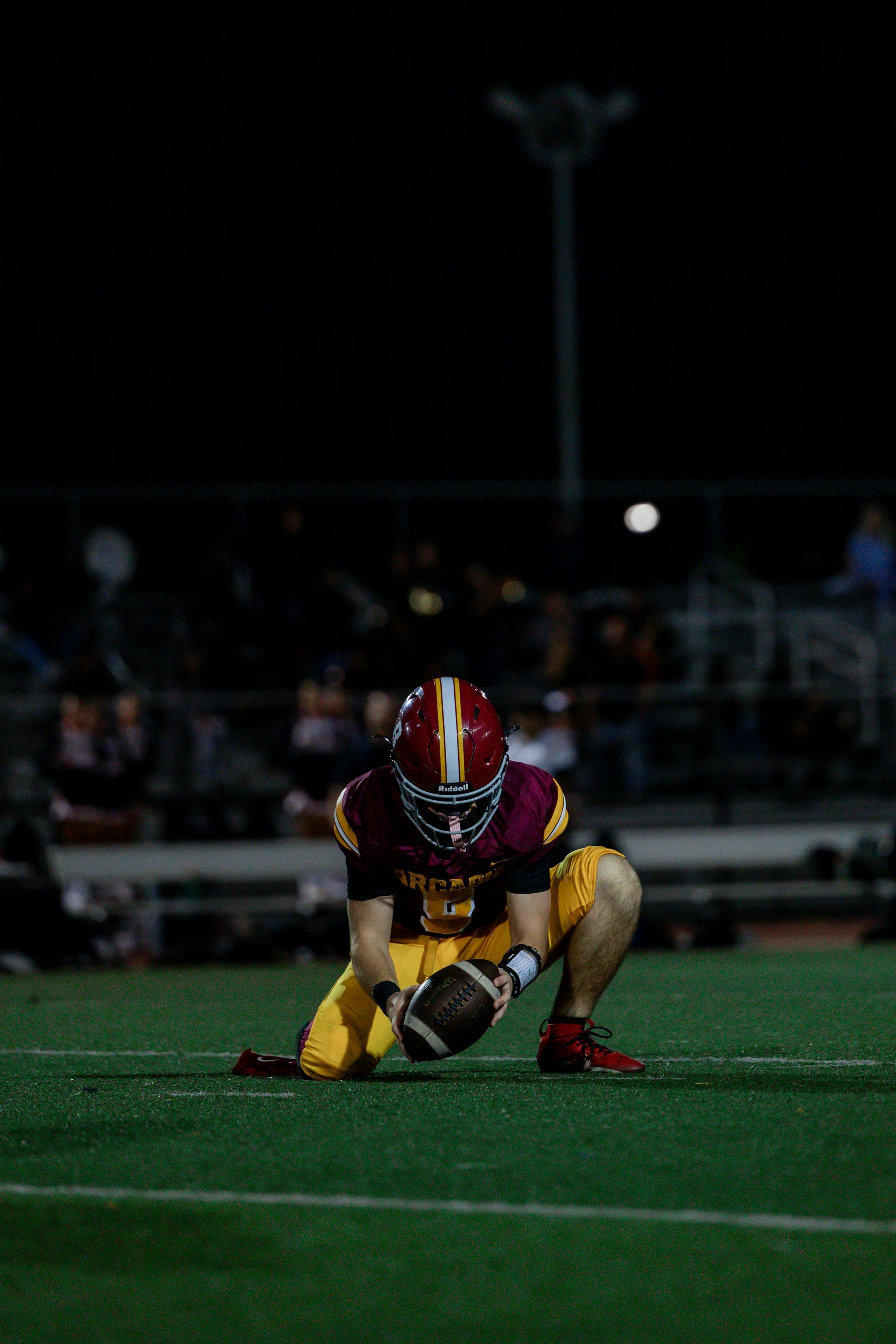 Football Player Preparing Hold for Place Kick · Free Stock Photo