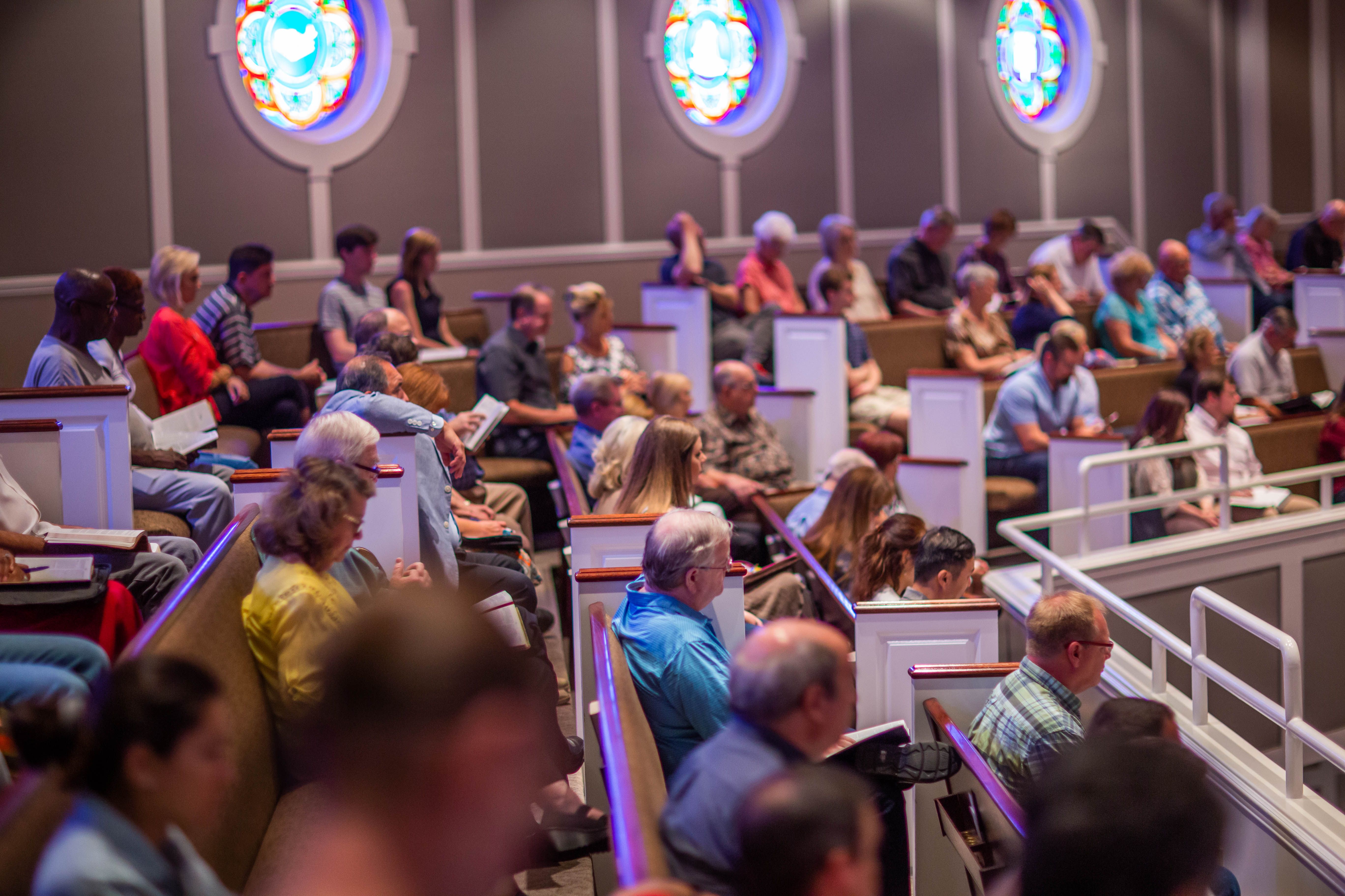 Audience in a Church with Stained Glass Windows · Free Stock Photo