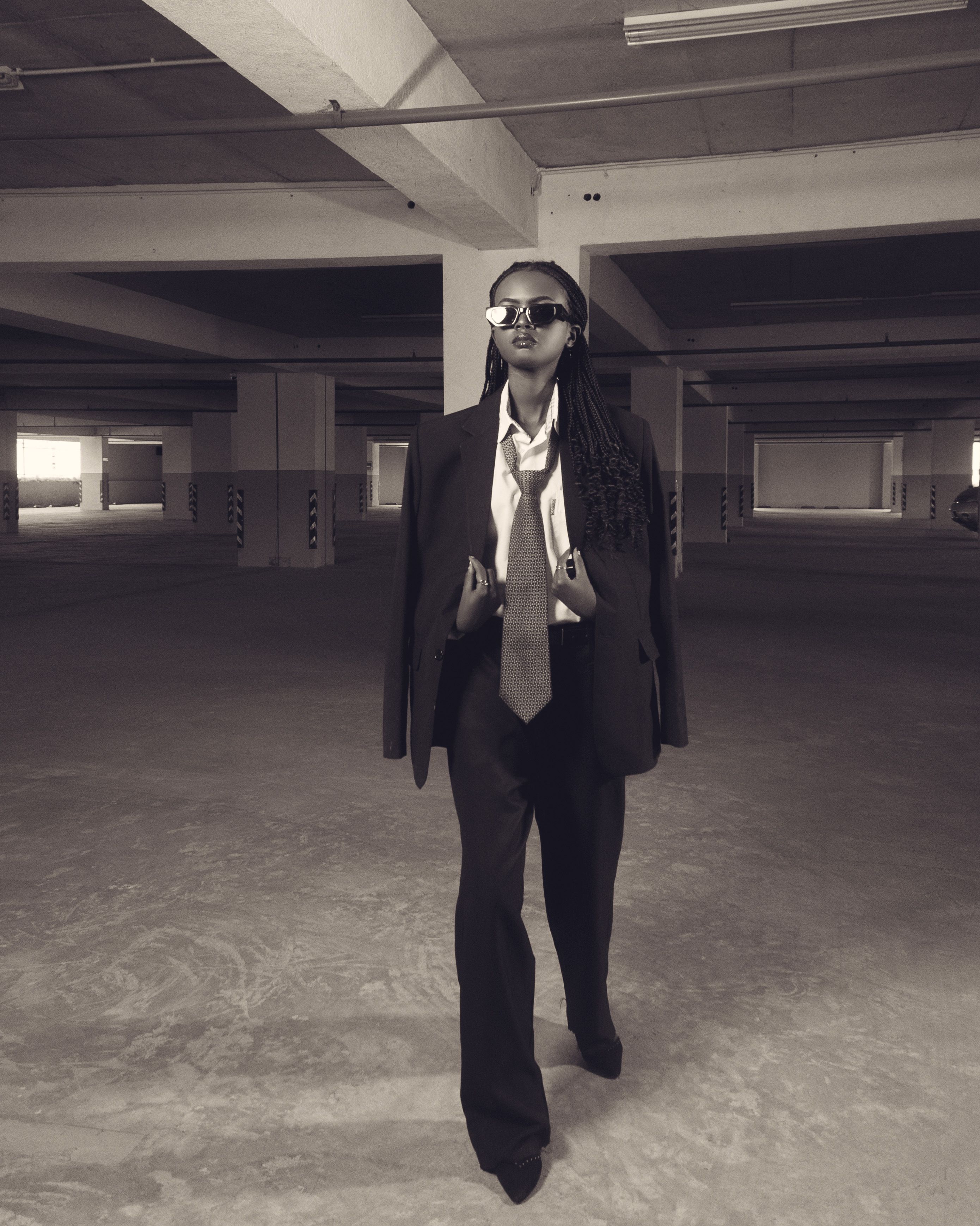 Fashionable Woman in Suit Walking Through Parking Garage · Free Stock Photo