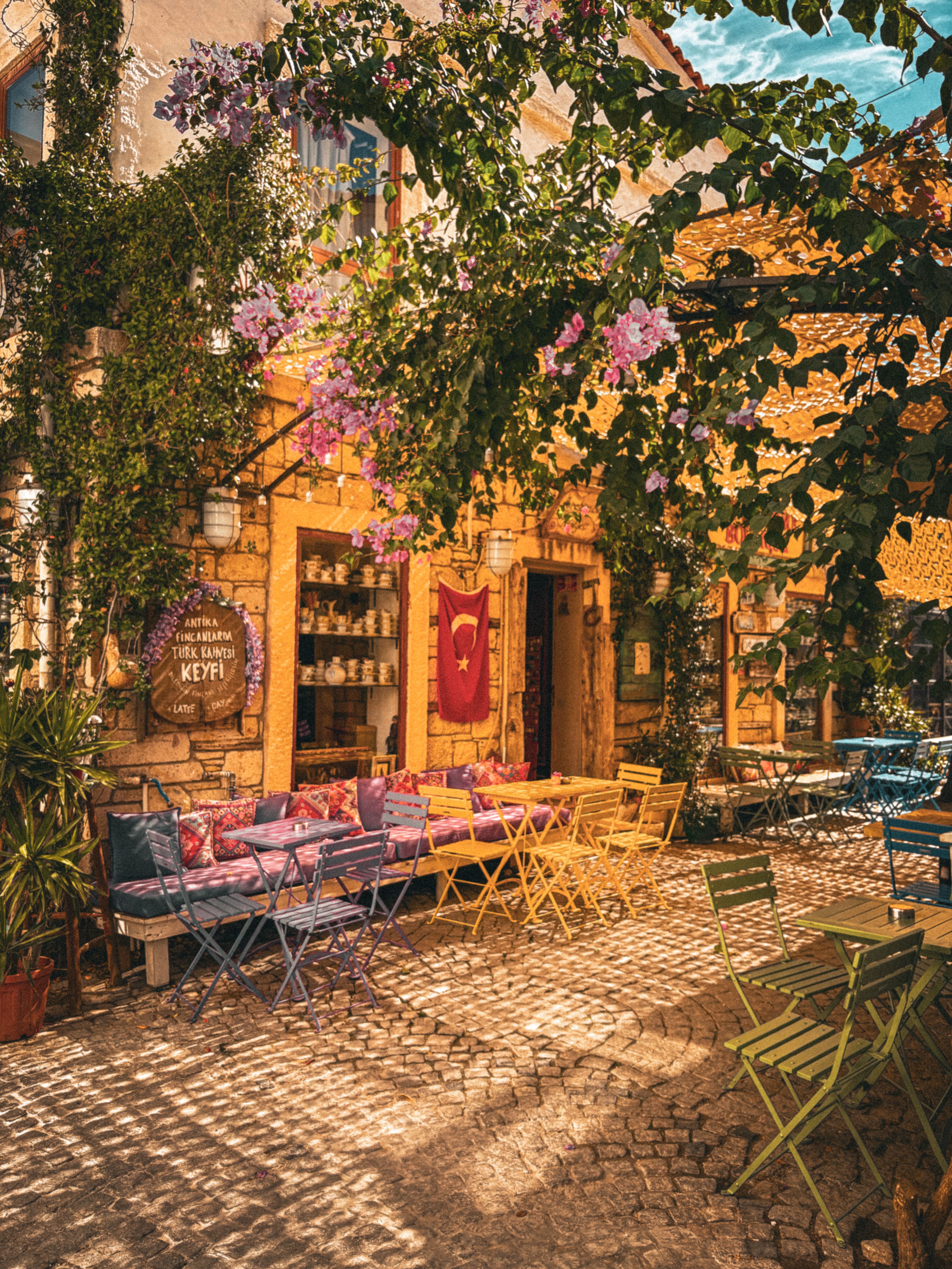 Charming Outdoor Cafe in a Sunlit Cobblestone Alley · Free Stock Photo