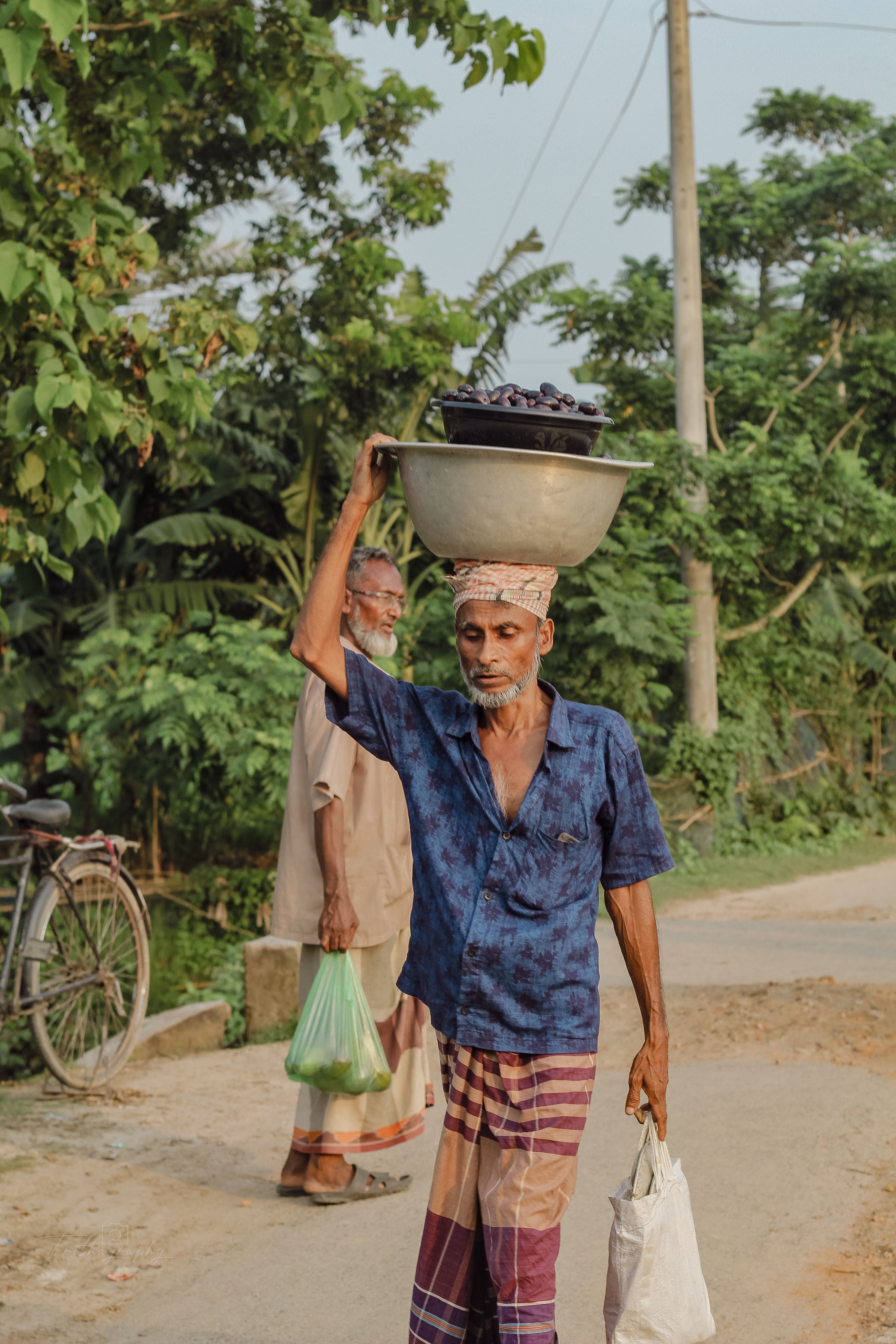Man carrying basket in rural village setting · Free Stock Photo