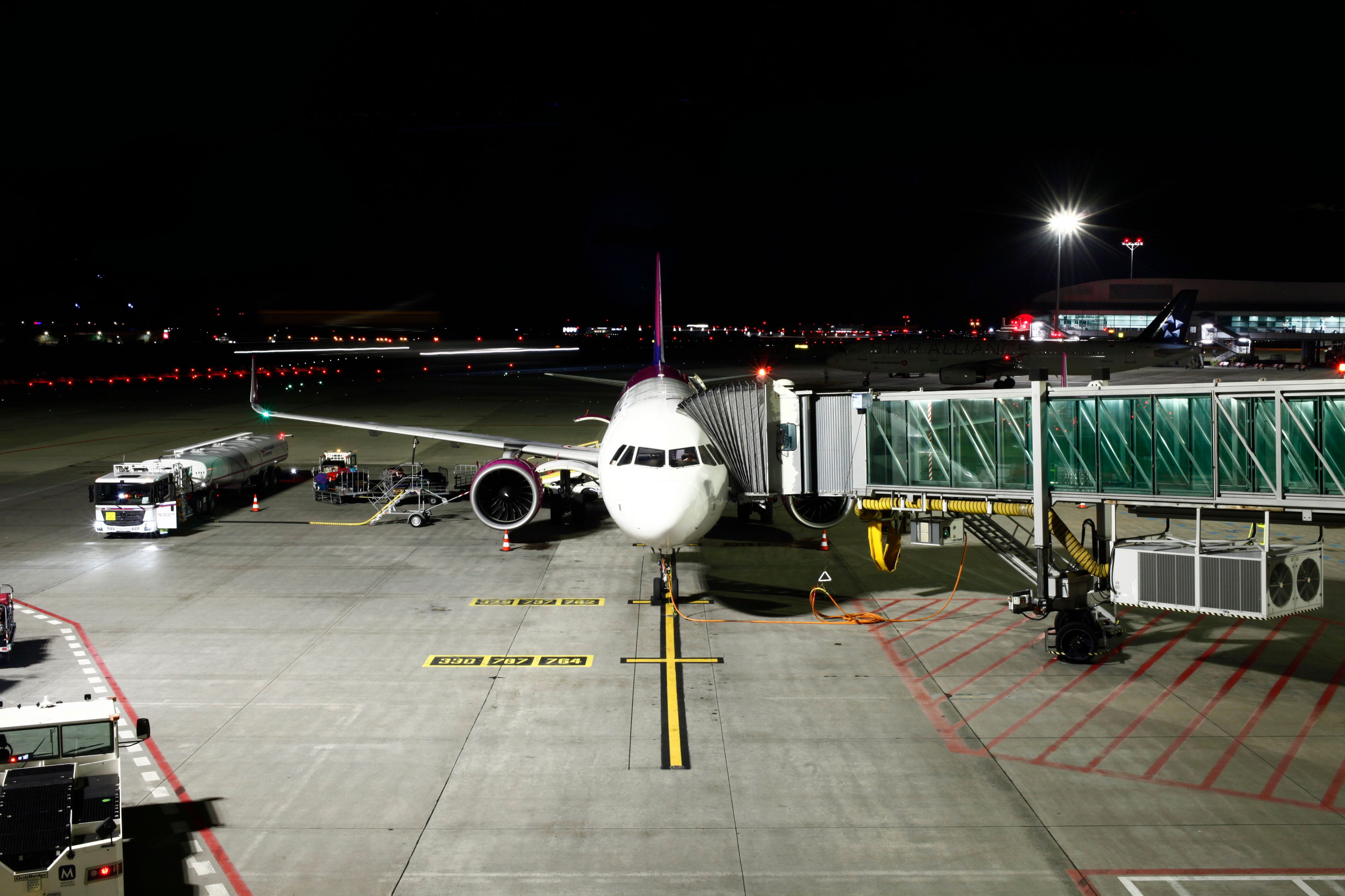 Airplane Docked at Airport Terminal at Night · Free Stock Photo