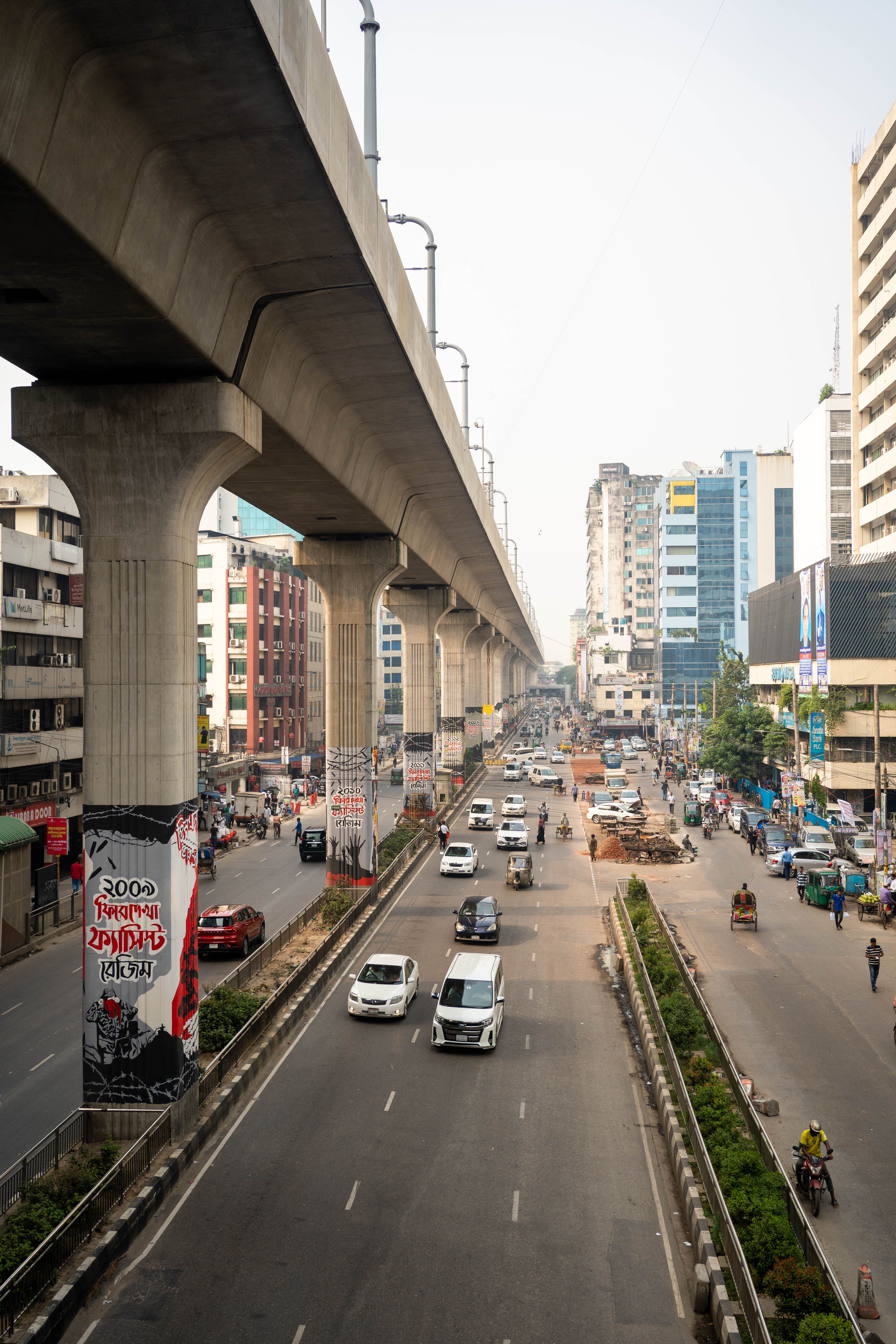 Busy Urban Street with Elevated Railway in Cityscape · Free Stock Photo