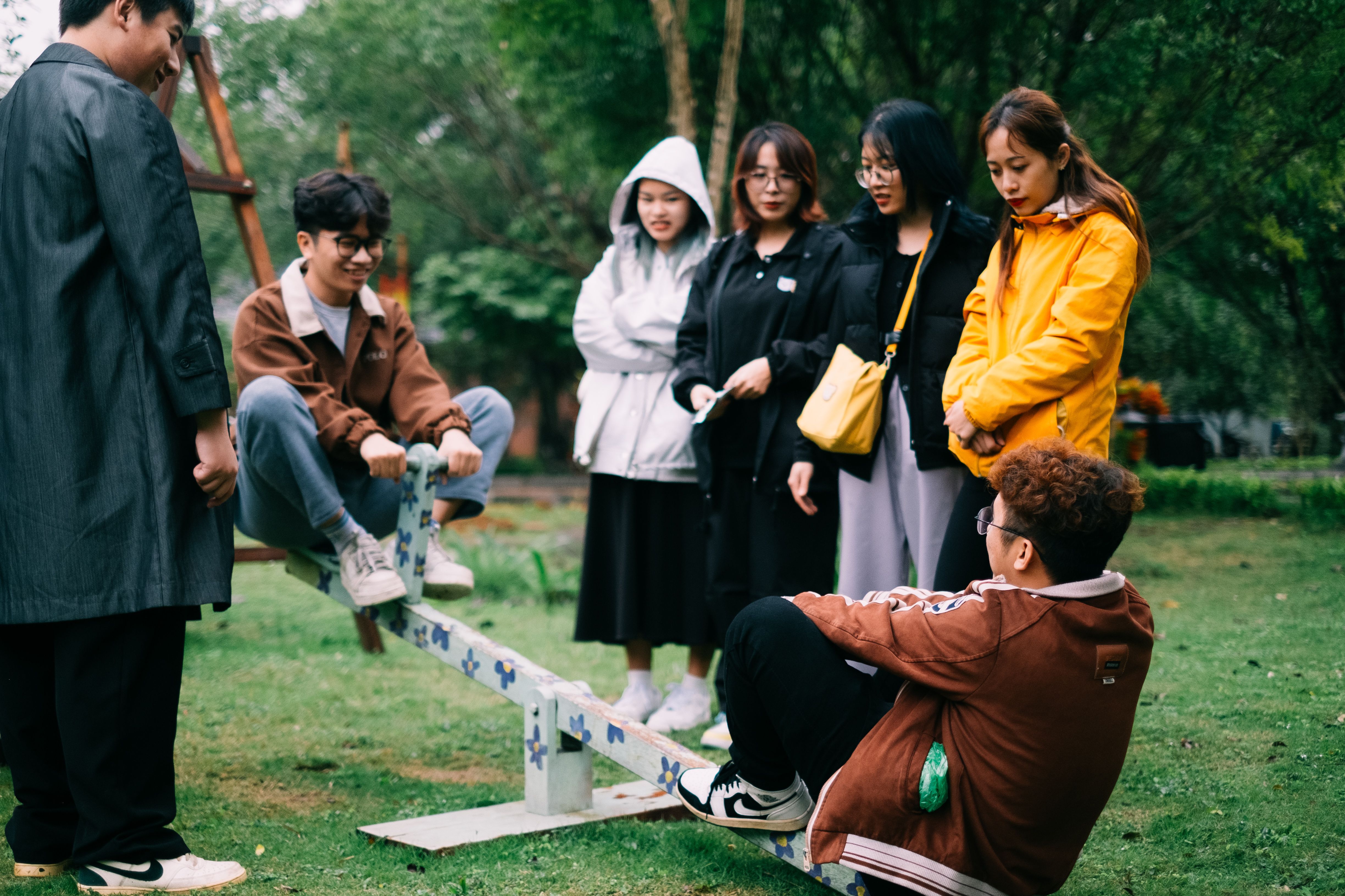 Group of Young Adults Enjoying Outdoor Seesaw · Free Stock Photo