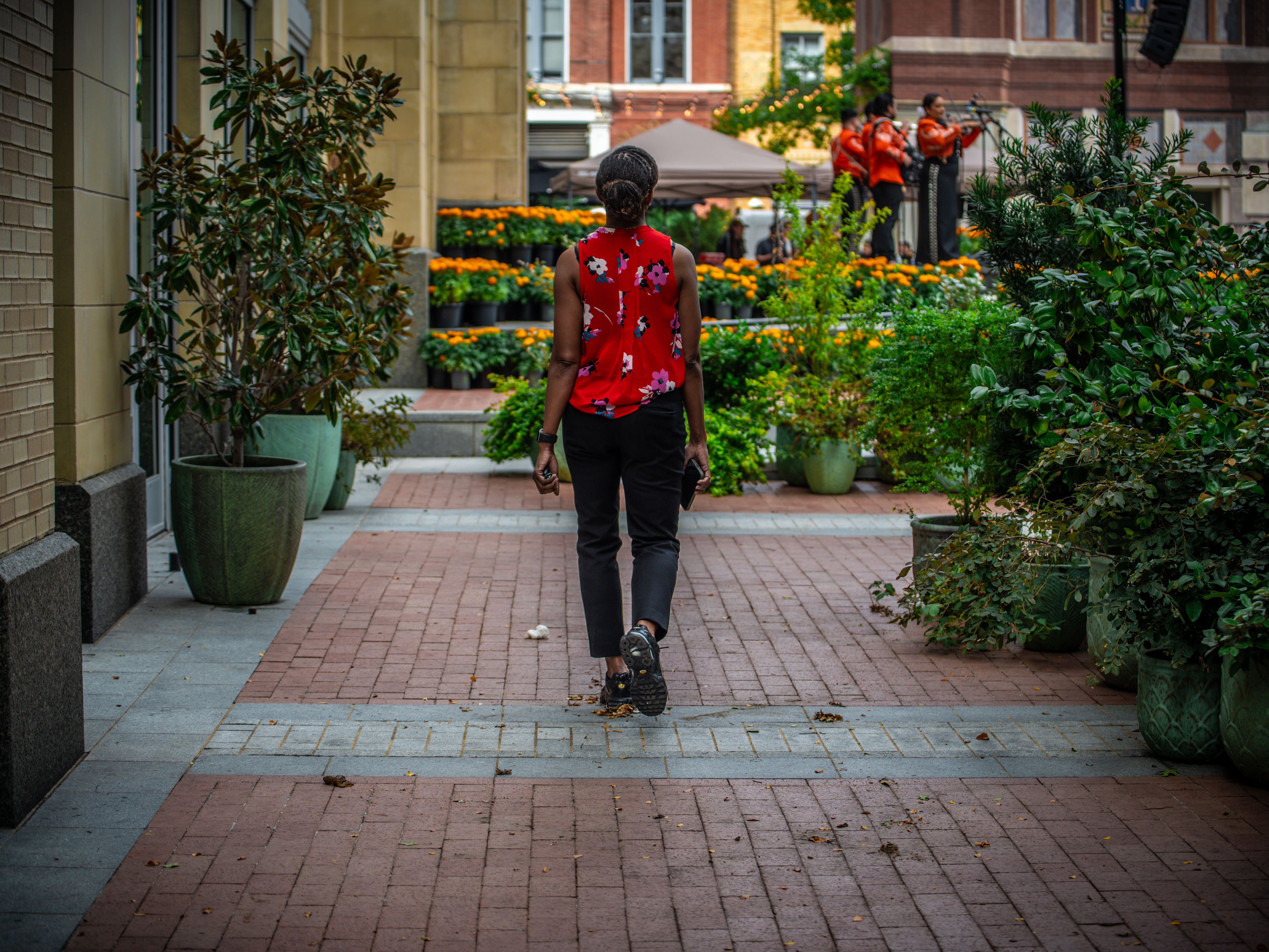 Woman Walking Outdoor Pathway in Urban Garden · Free Stock Photo