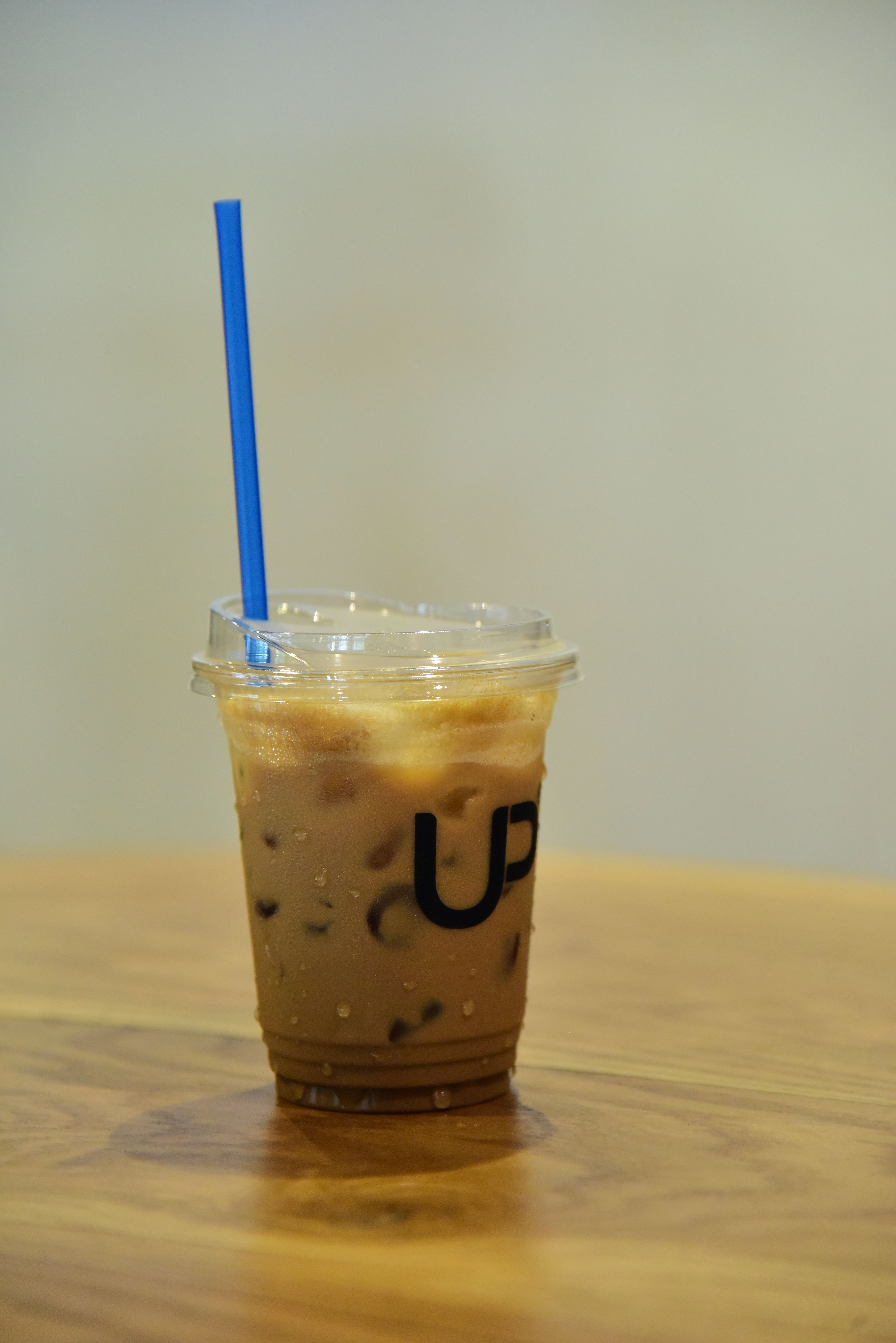 Iced Coffee with Straw on Wooden Table · Free Stock Photo