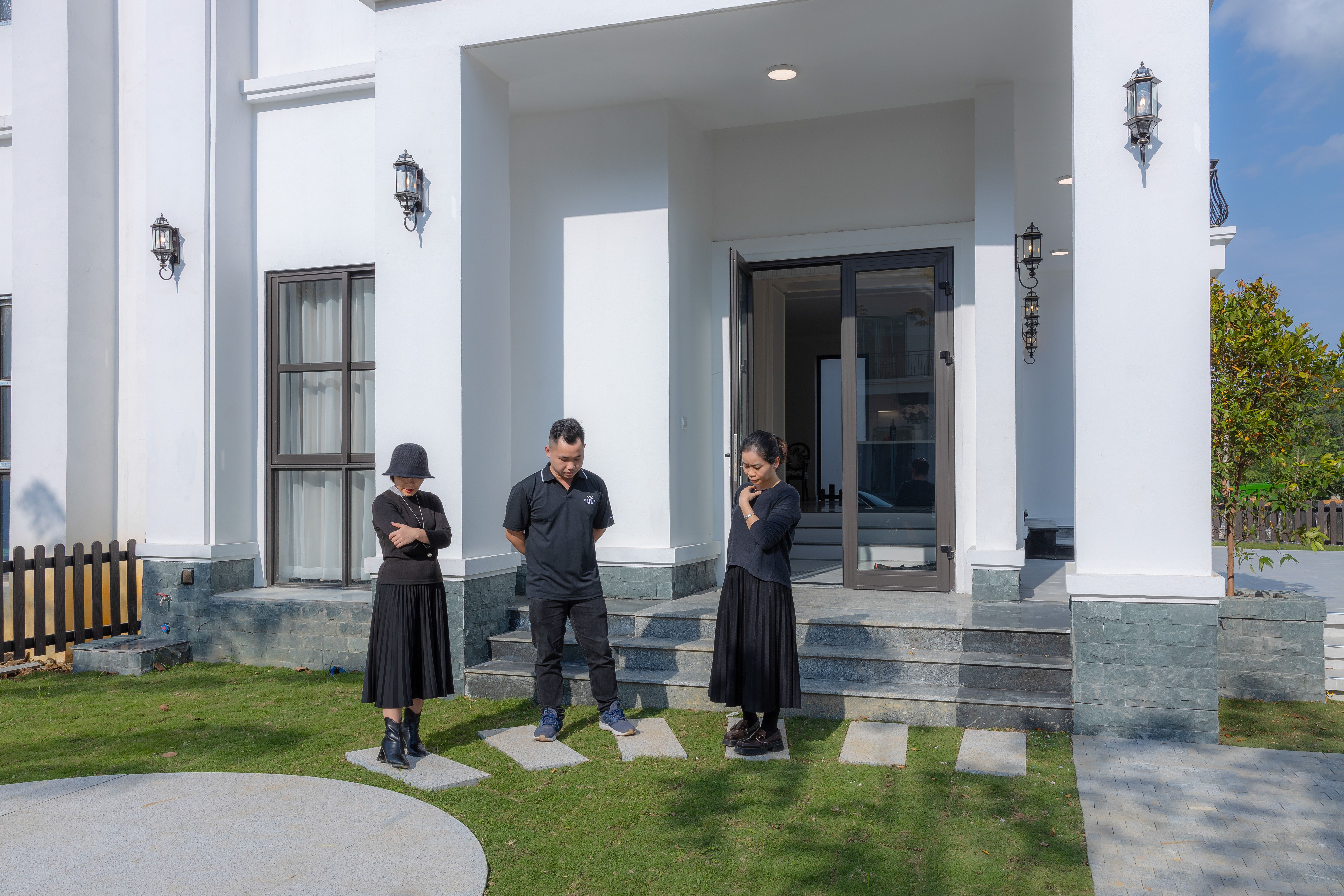 Three People Standing in Front of Modern House · Free Stock Photo