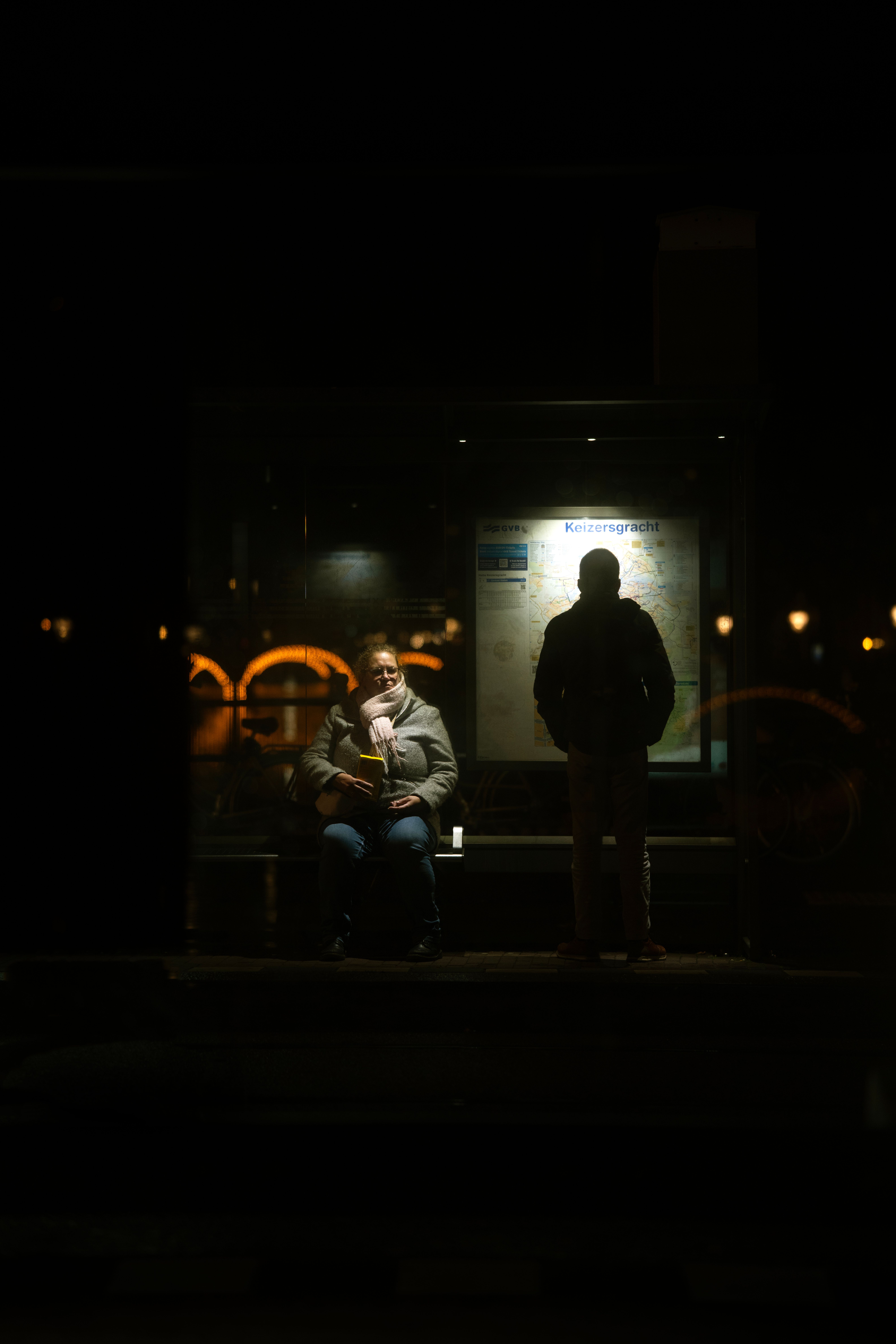 Night Scene at Bus Stop Featuring Two Individuals · Free Stock Photo
