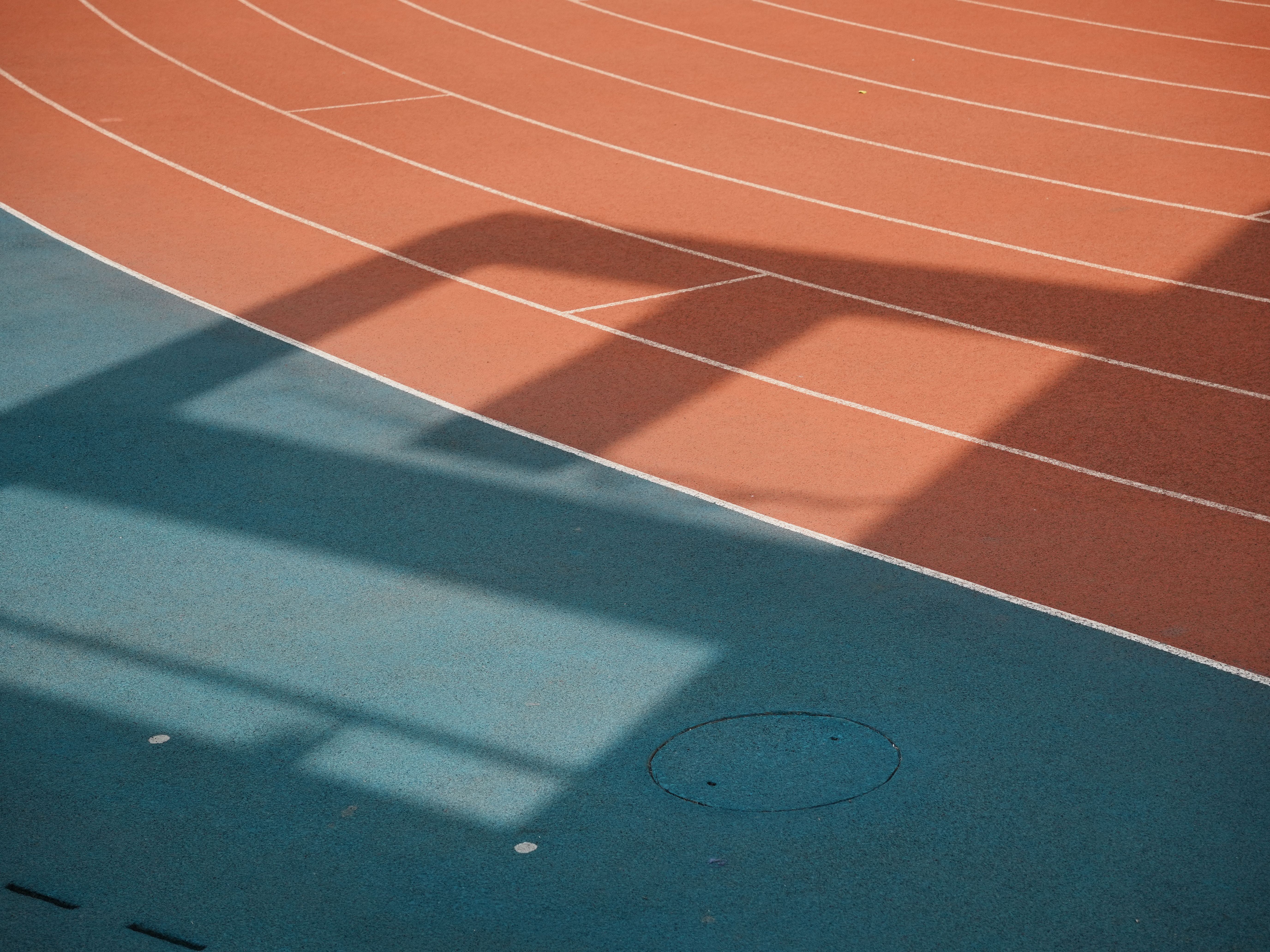 Shadow Play on Track and Field Lines · Free Stock Photo