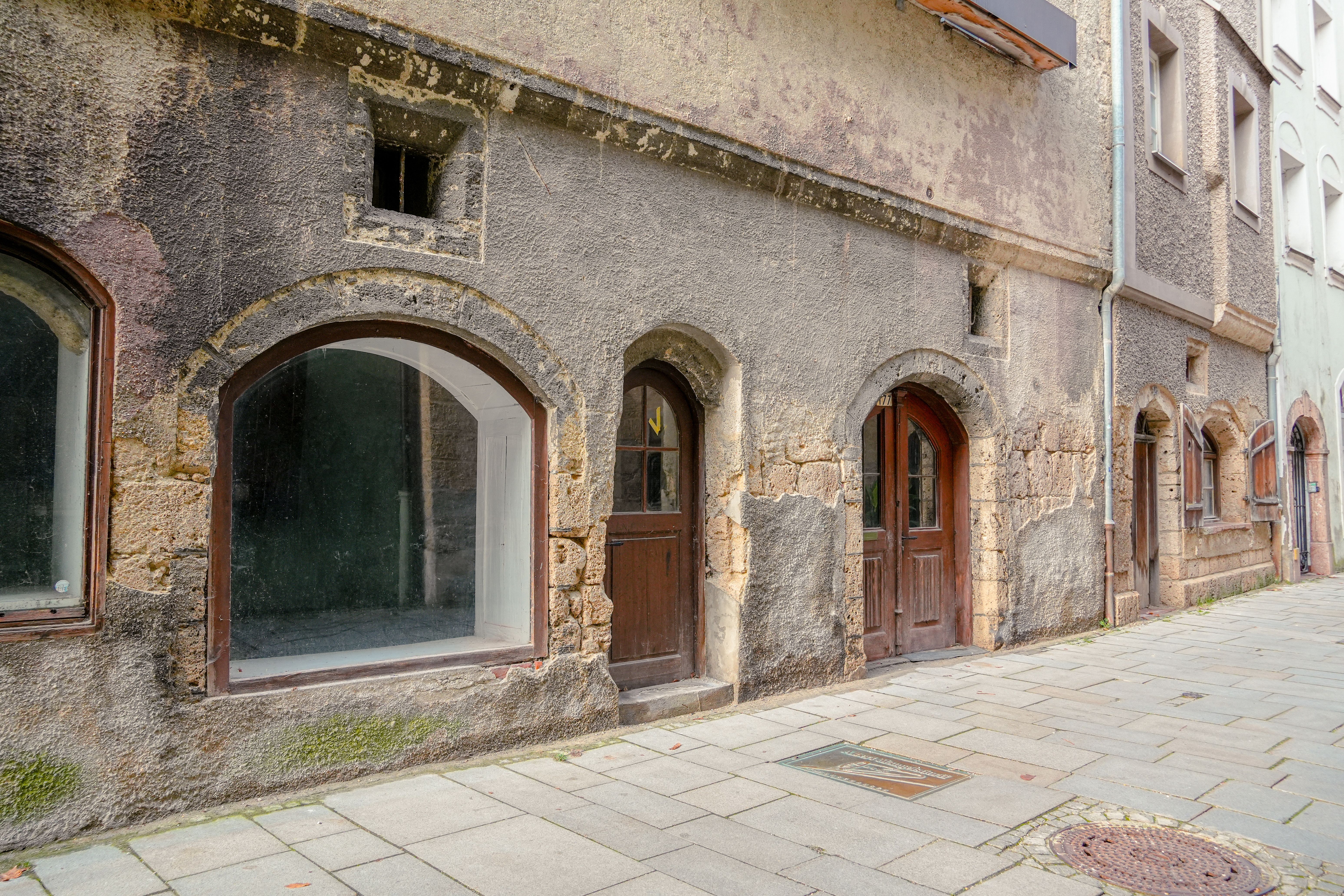 Historic Stone Building Facade with Arched Doorways · Free Stock Photo
