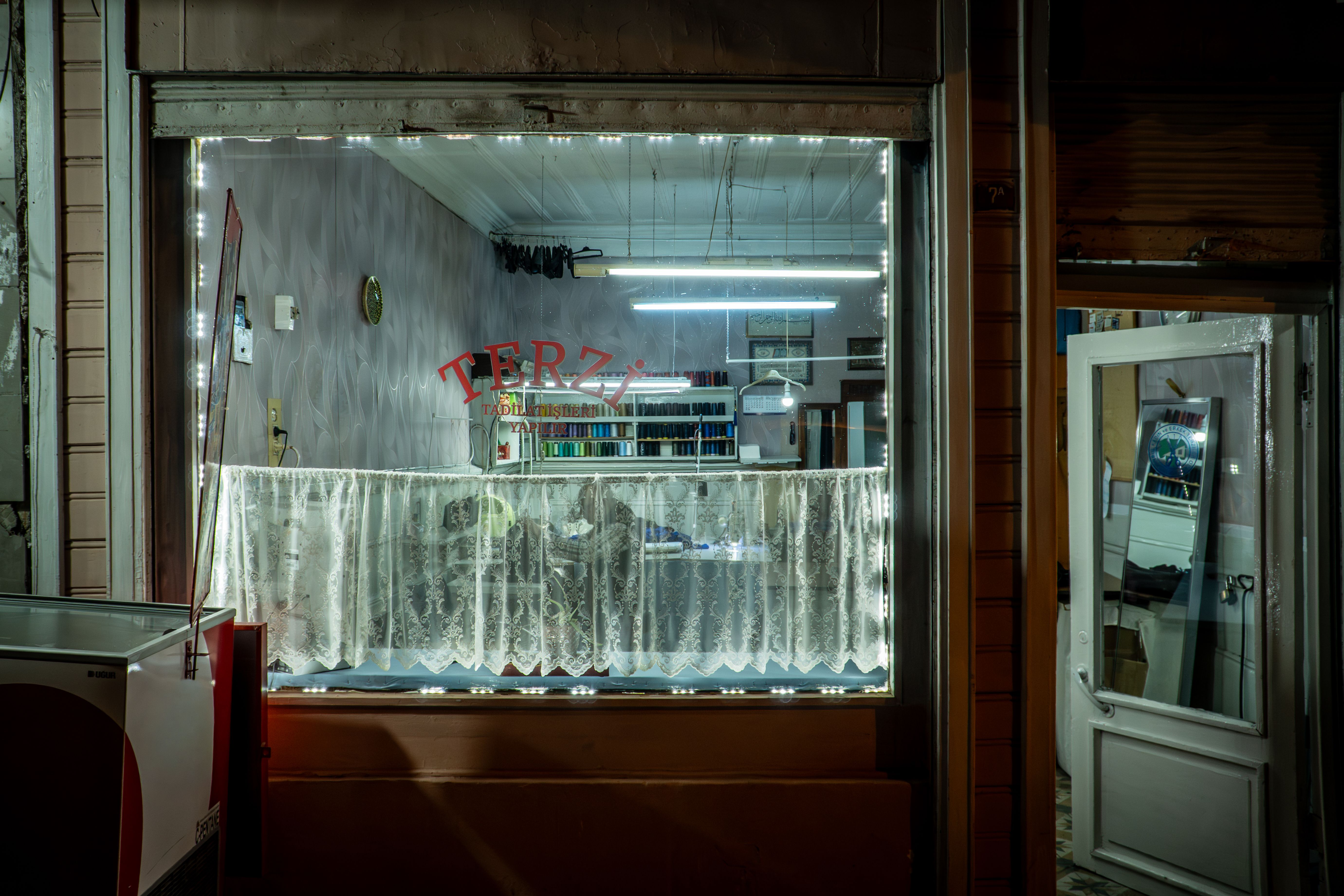 Charming Night View of Tailor Shop Window Display · Free Stock Photo