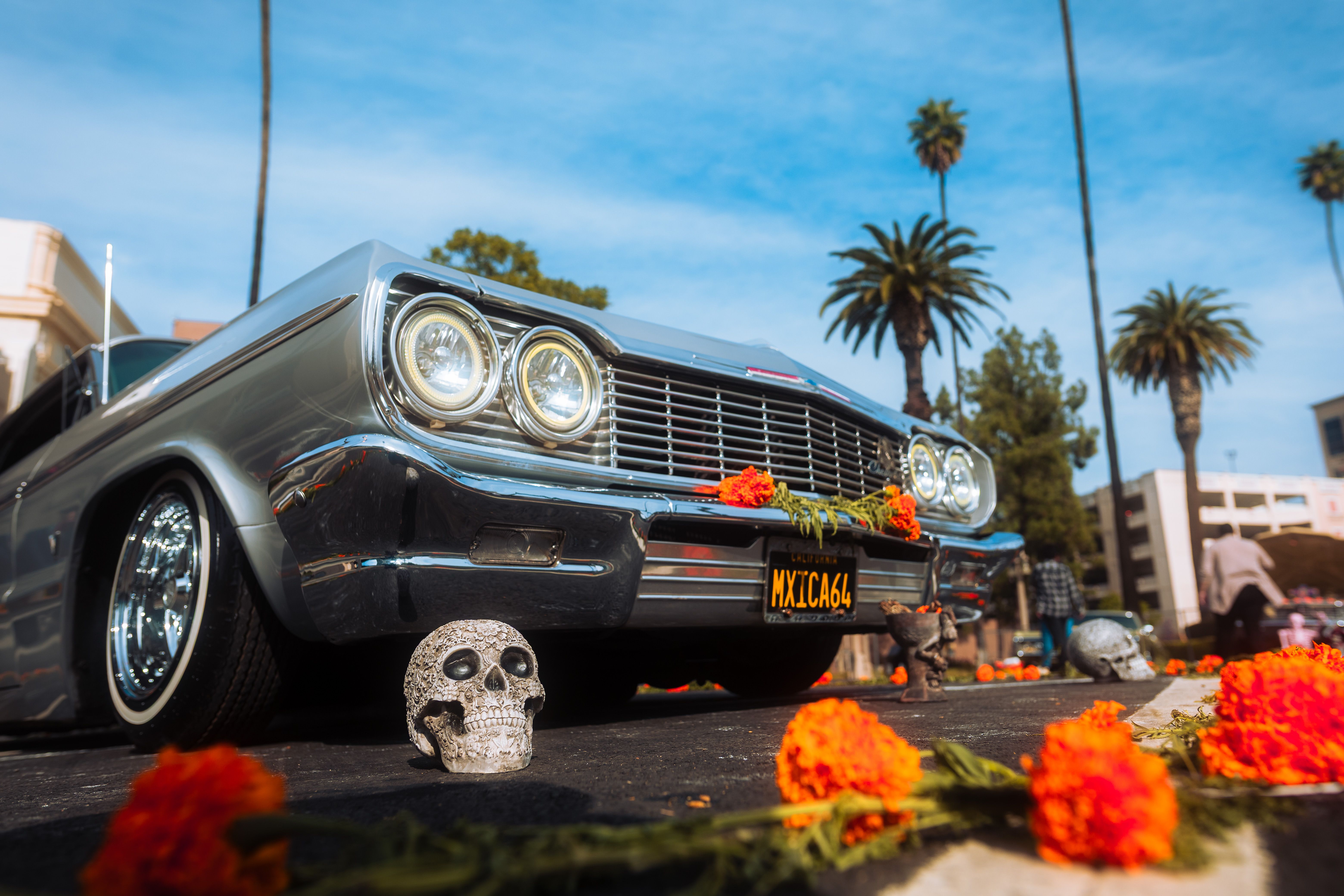 Classic car decorated with marigolds and skulls · Free Stock Photo