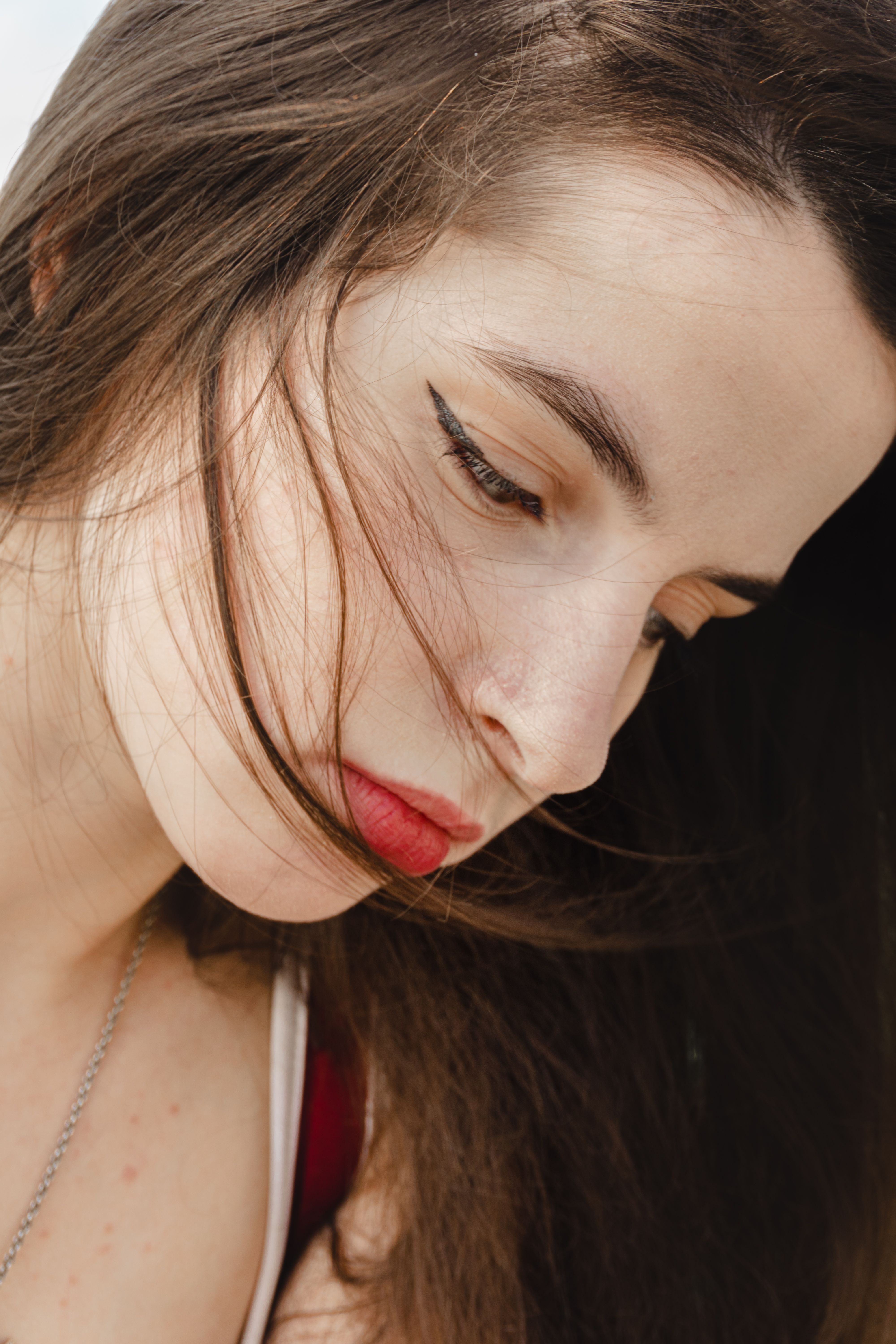 Portrait of a Thoughtful Woman with Windblown Hair · Free Stock Photo