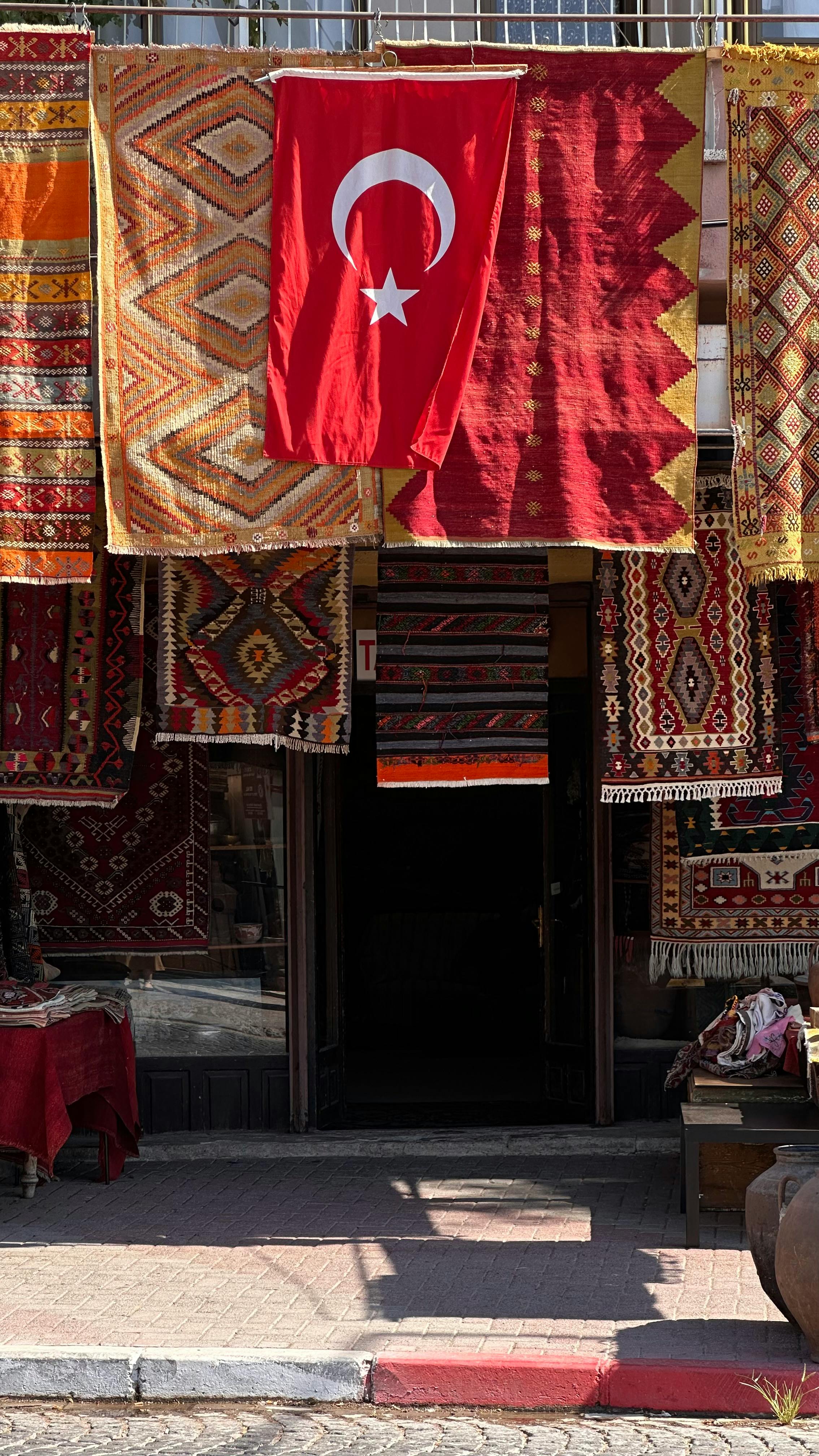 Traditional Turkish Rugs and Flag in Market Display · Free Stock Photo
