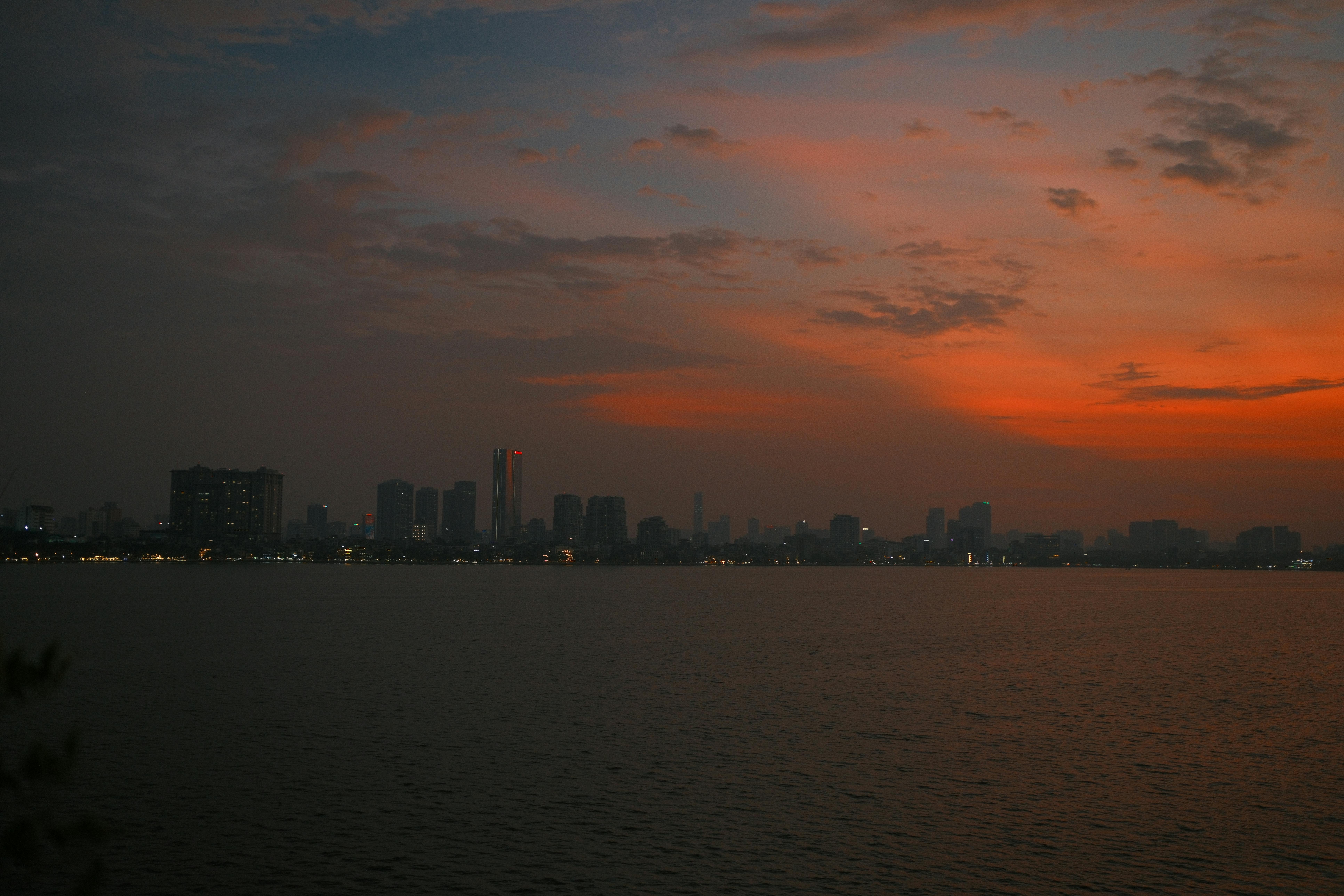 Dramatic Sunset Over City Skyline and Water · Free Stock Photo