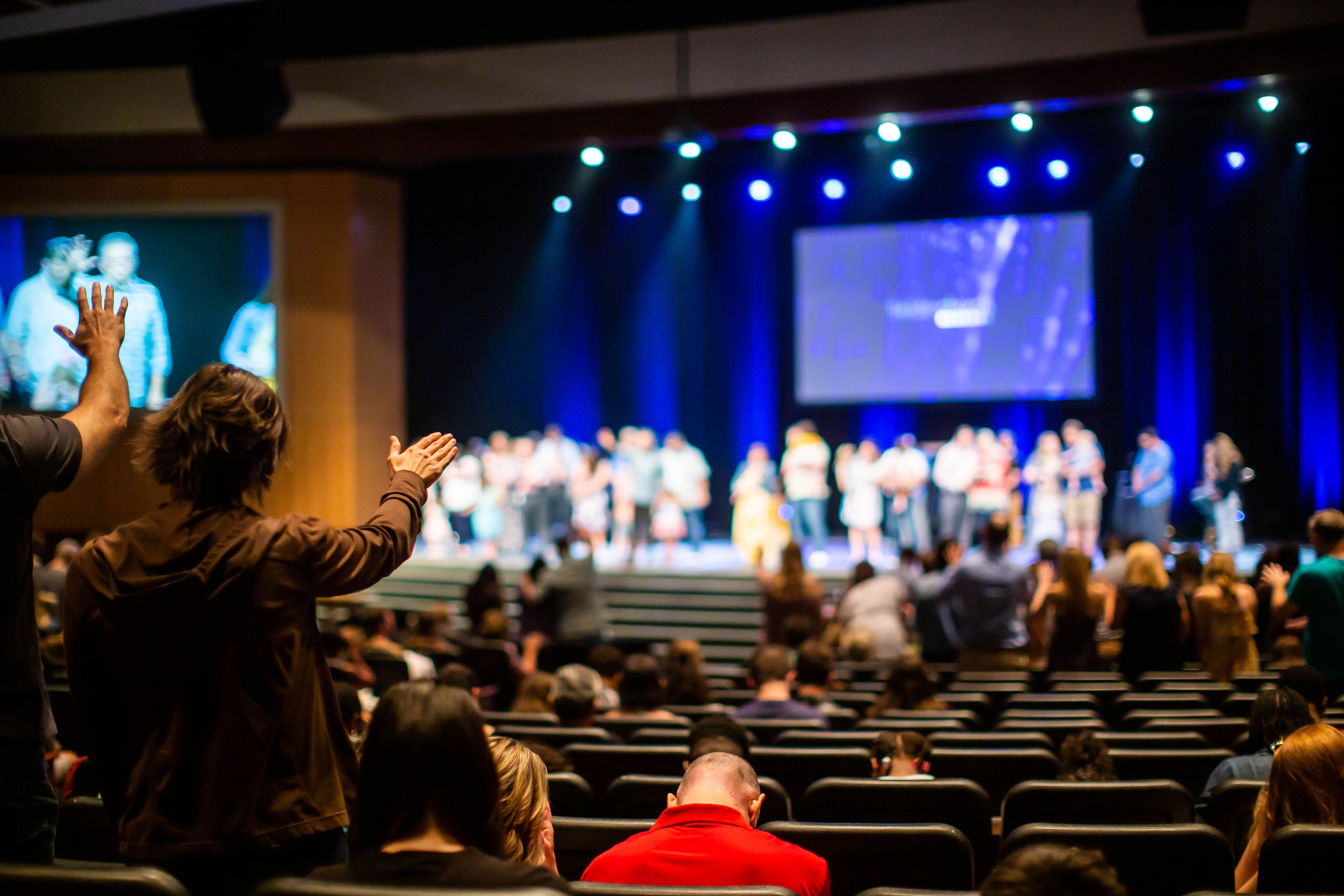 Vibrant Indoor Event with Audience and Stage · Free Stock Photo