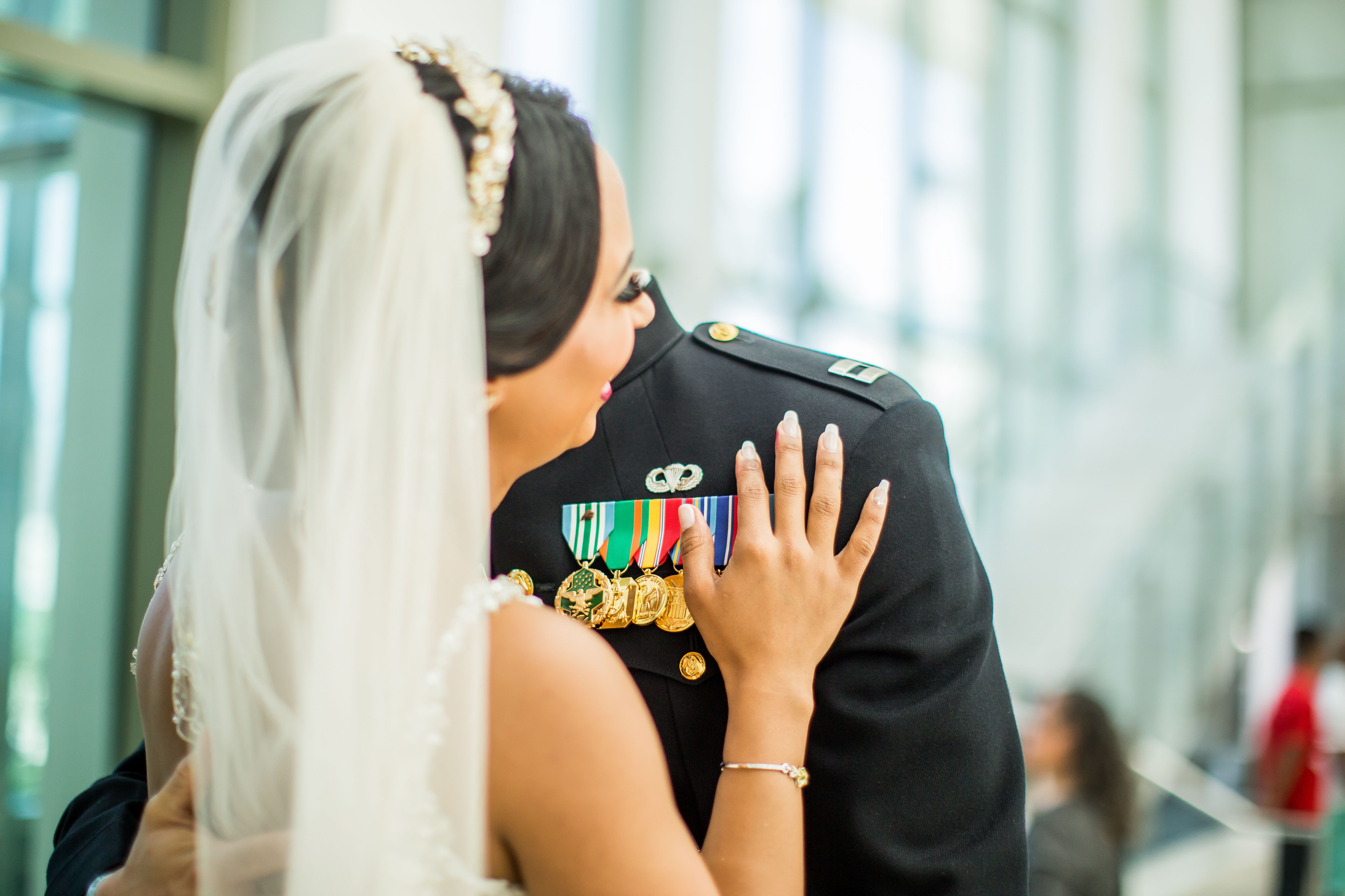 Bride Embraces Military Groom in Indoor Wedding · Free Stock Photo