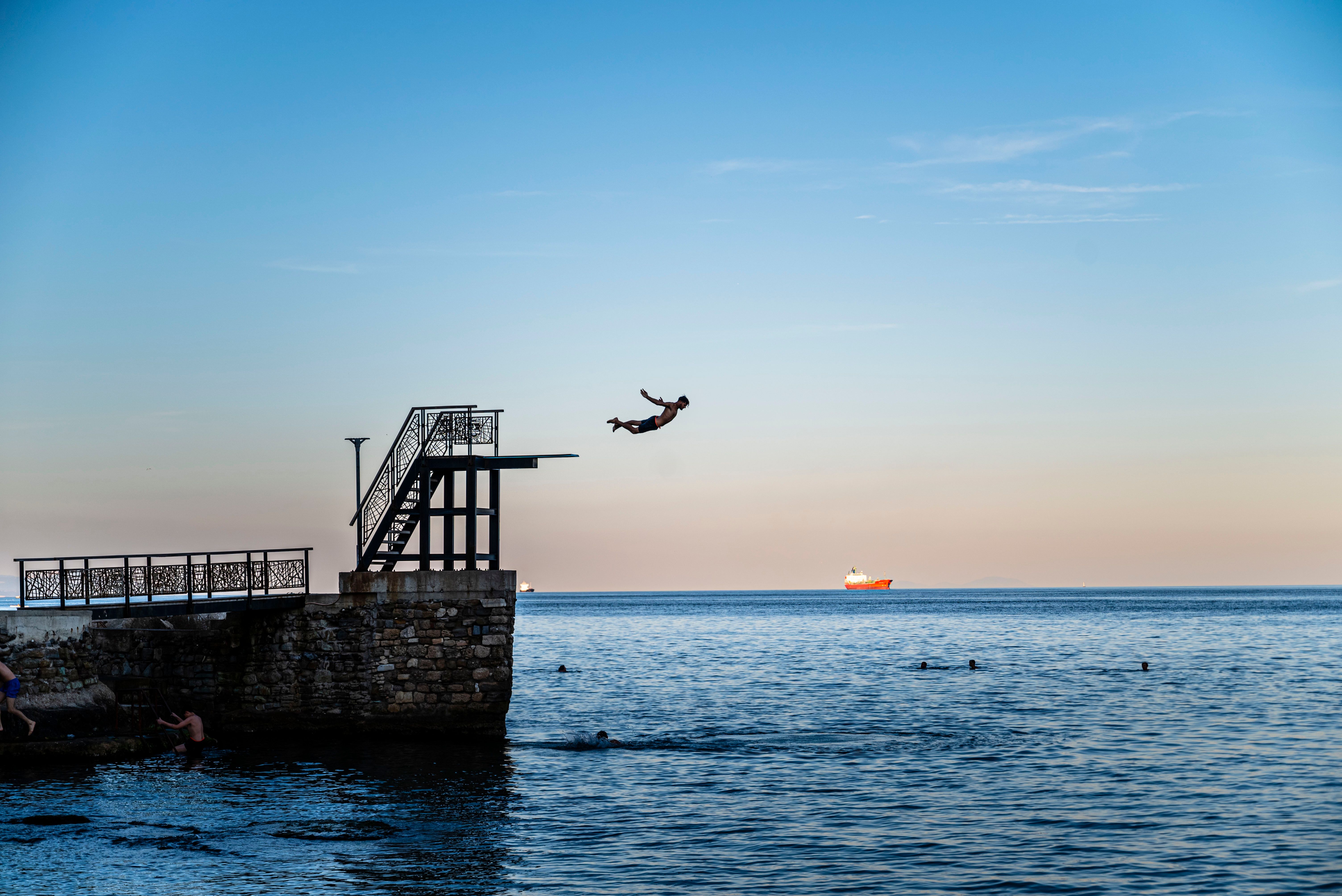 Diving off Pier at Sunset into the Ocean · Free Stock Photo