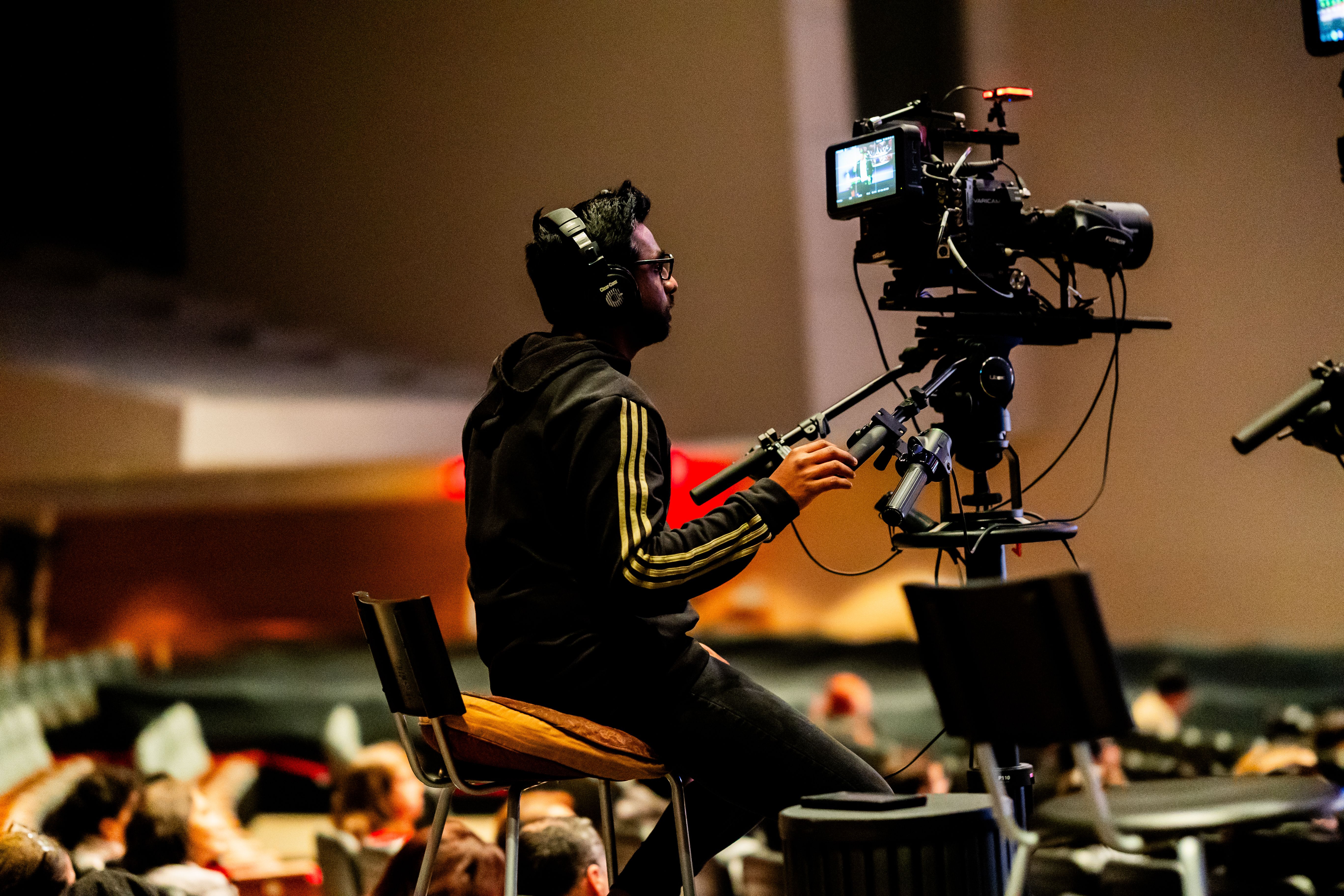Cameraman Filming with Professional Equipment Indoors · Free Stock Photo